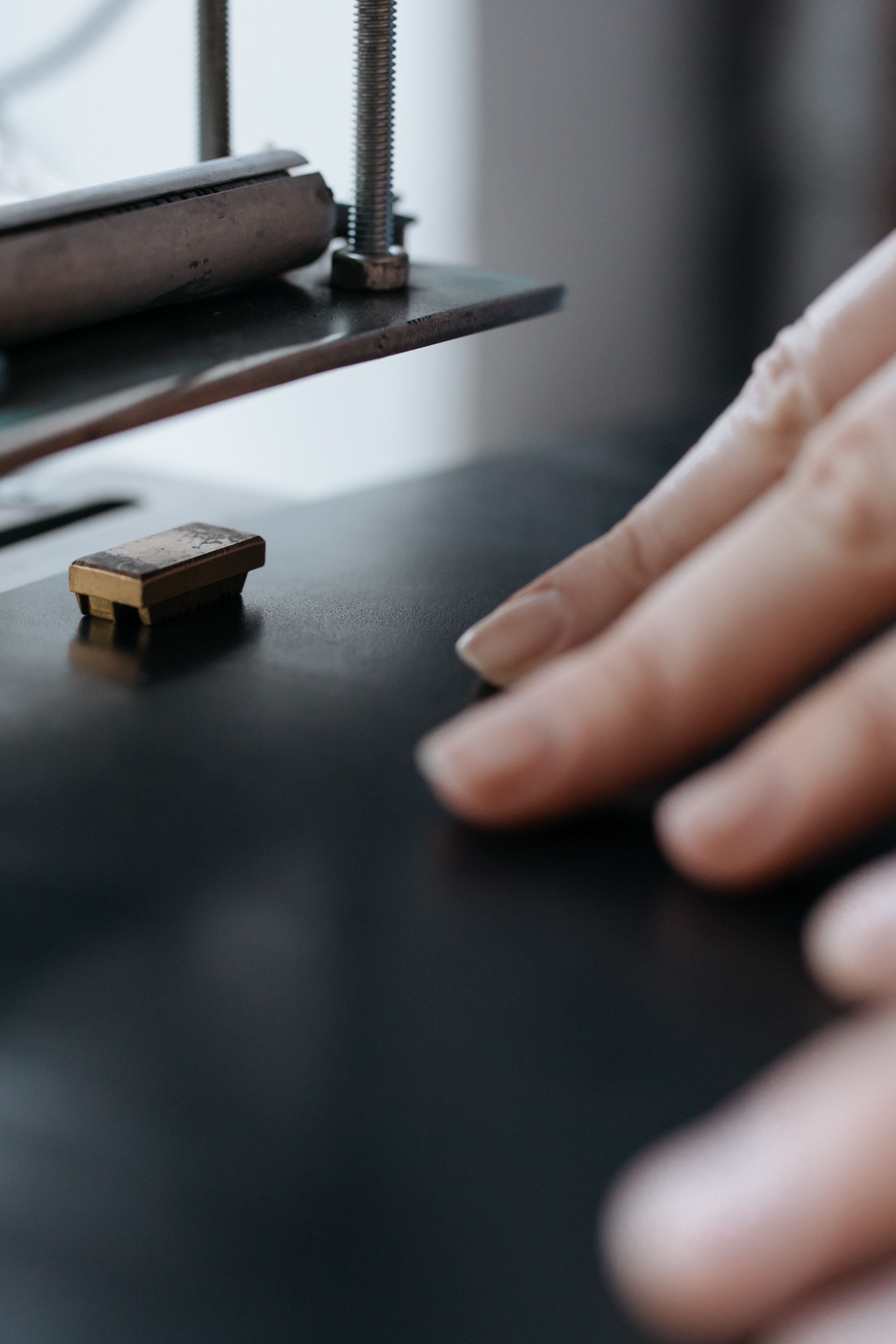 A Person Guiding a Black Material into a Machine · Free Stock Photo