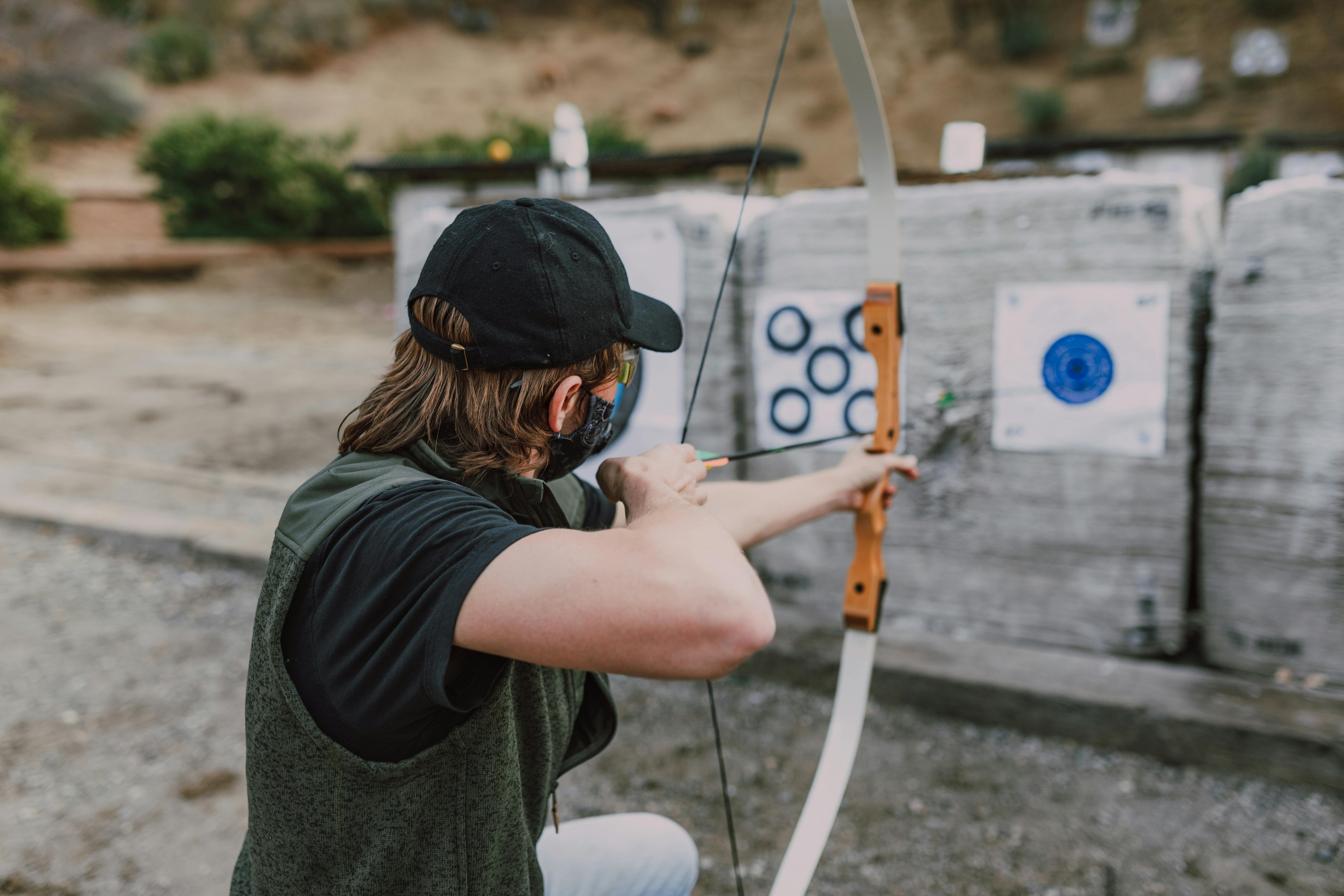Person Holding a Bow and Arrow · Free Stock Photo