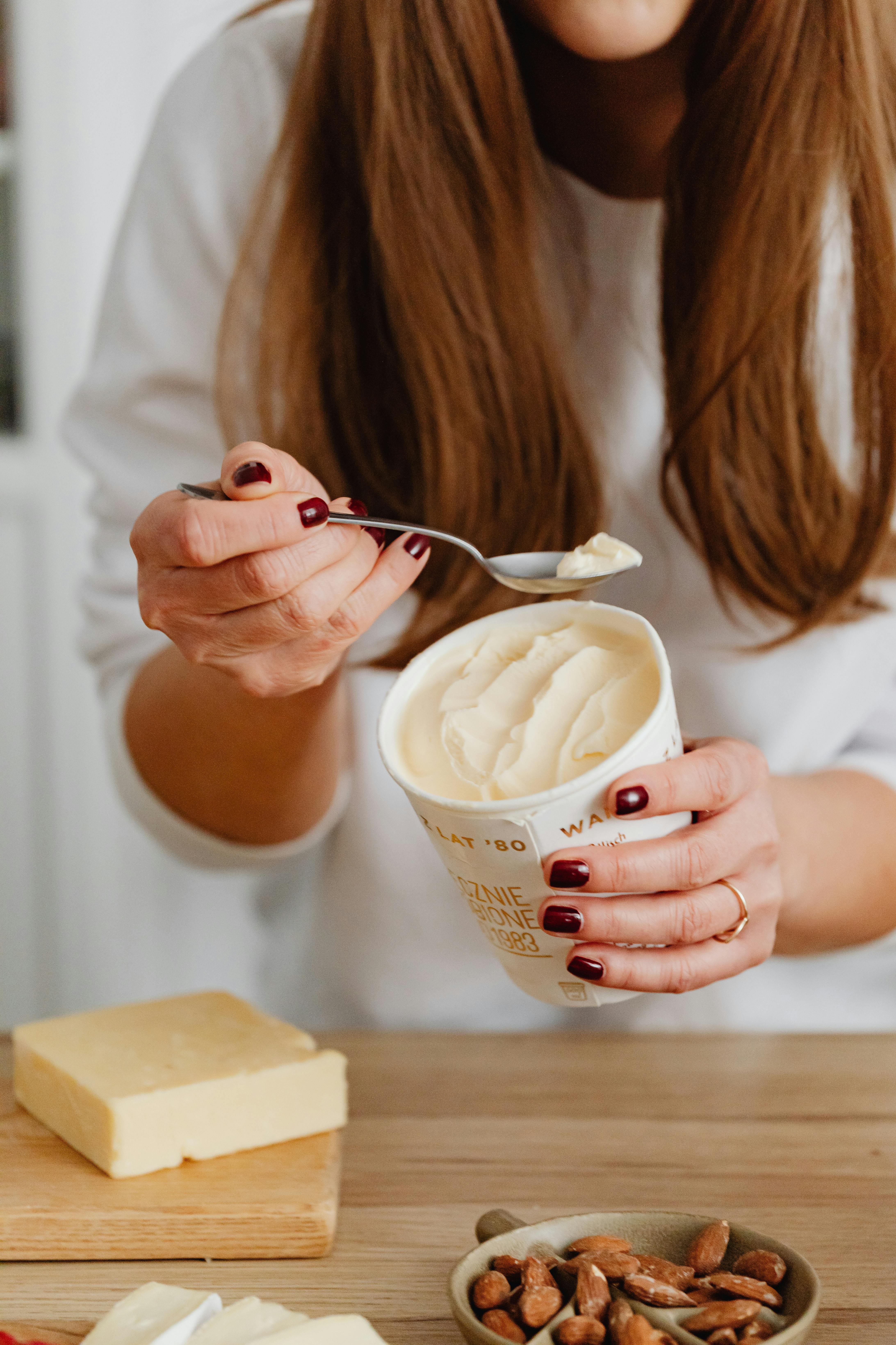 Woman Holding a Spoon with Vanilla Ice Cream · Free Stock Photo