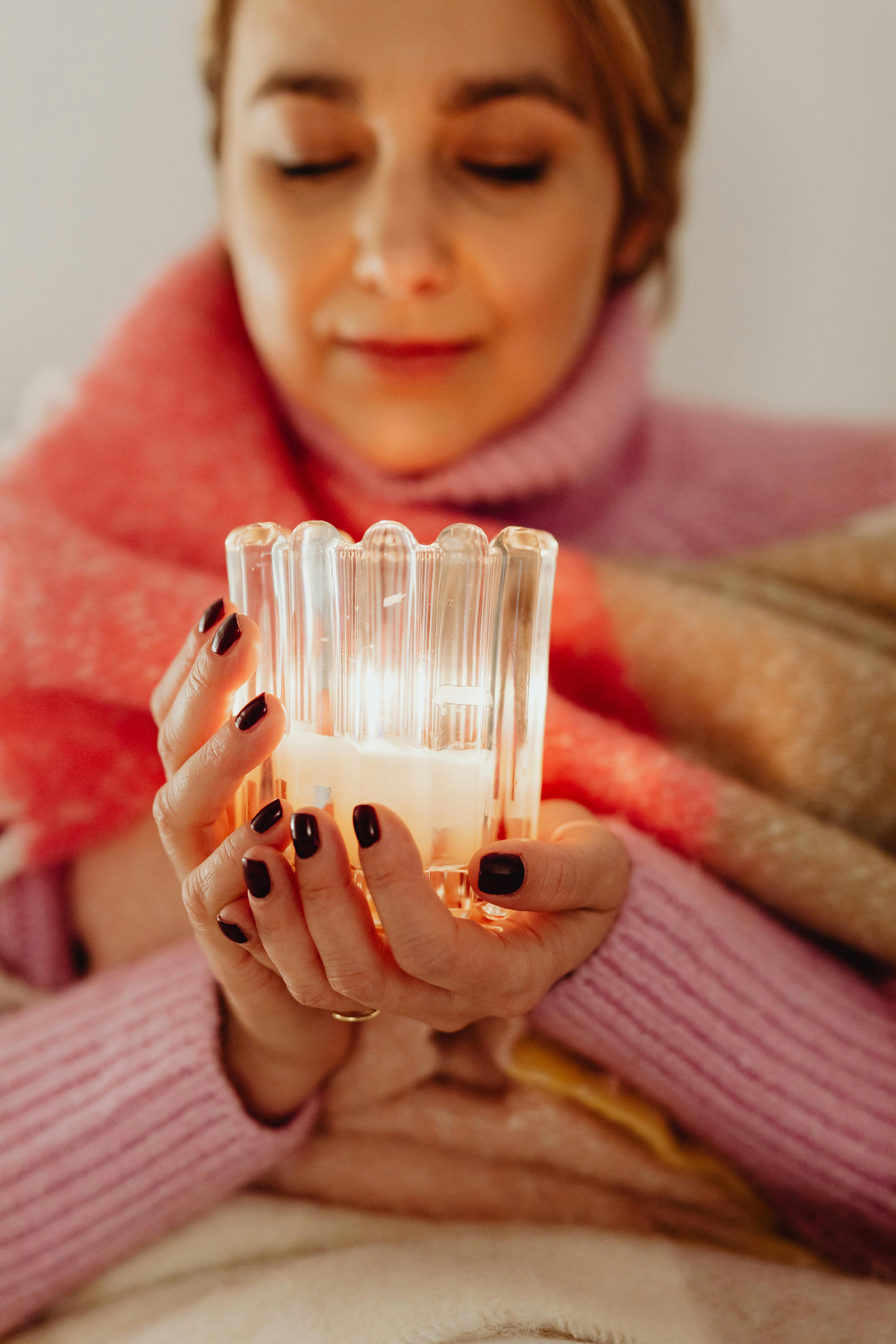 A Woman Holding Lighted Candle in a Smokey Dark Room · Free Stock Photo
