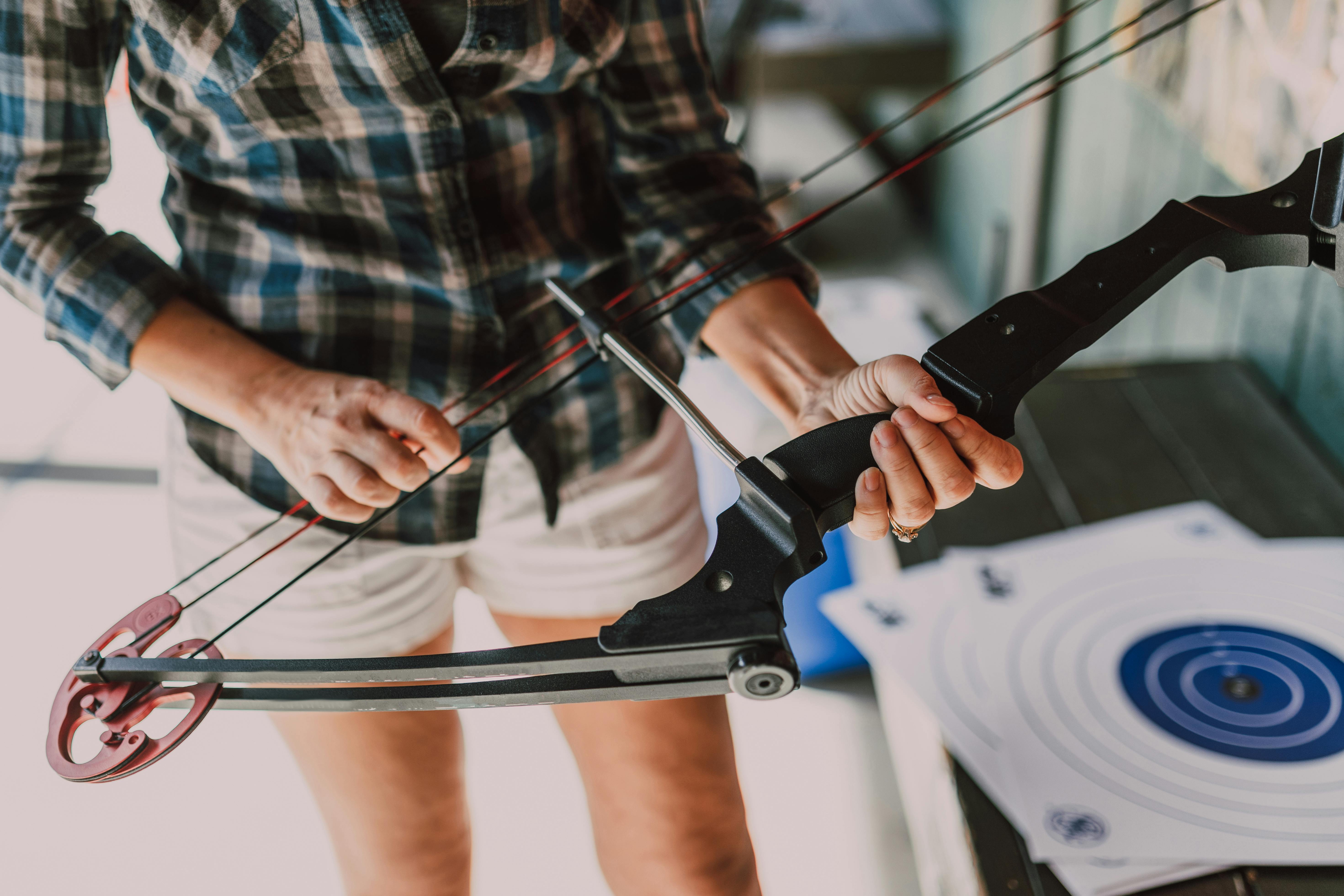 Person Holding a Compound Bow · Free Stock Photo