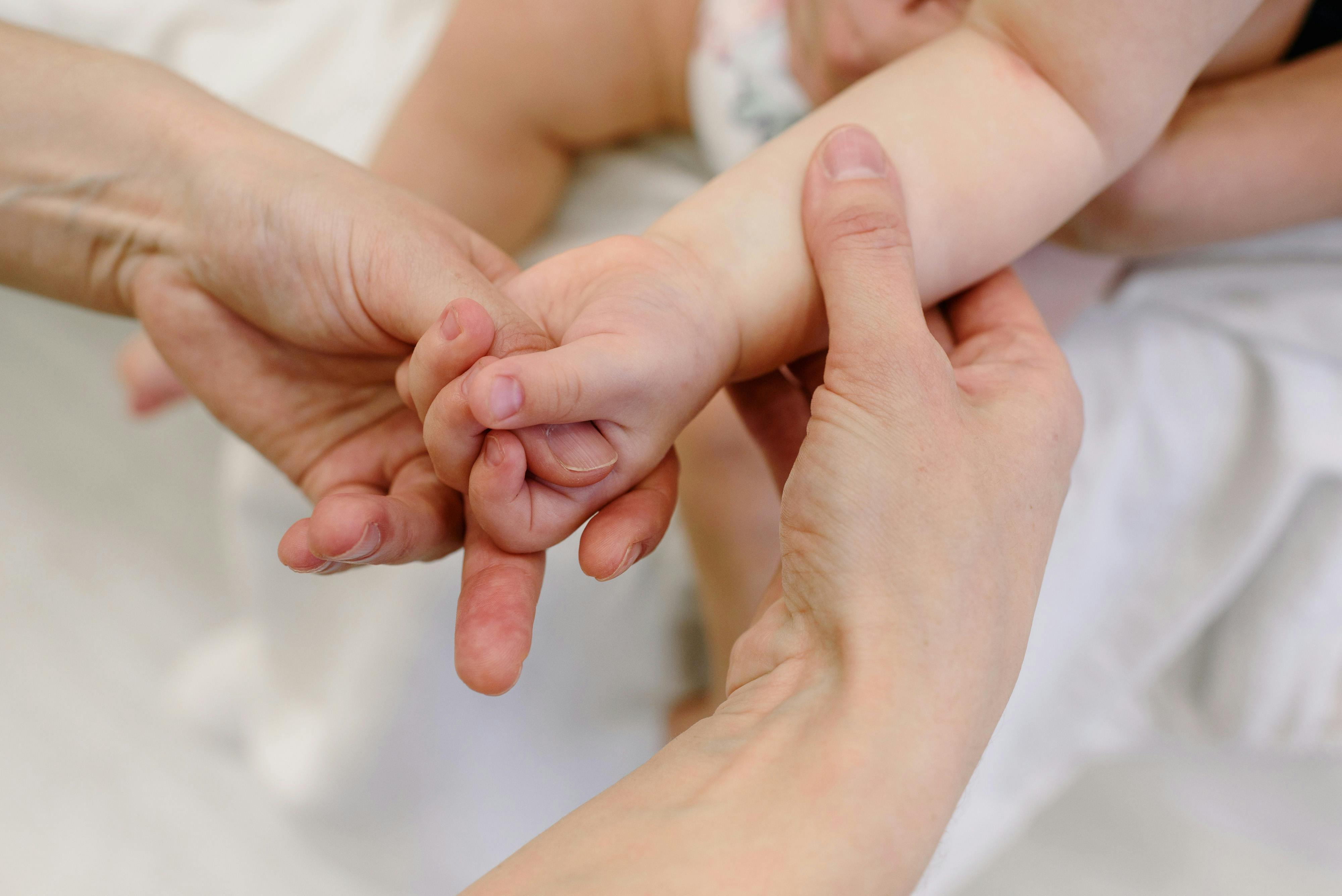 Person Massaging a Baby's Hand · Free Stock Photo