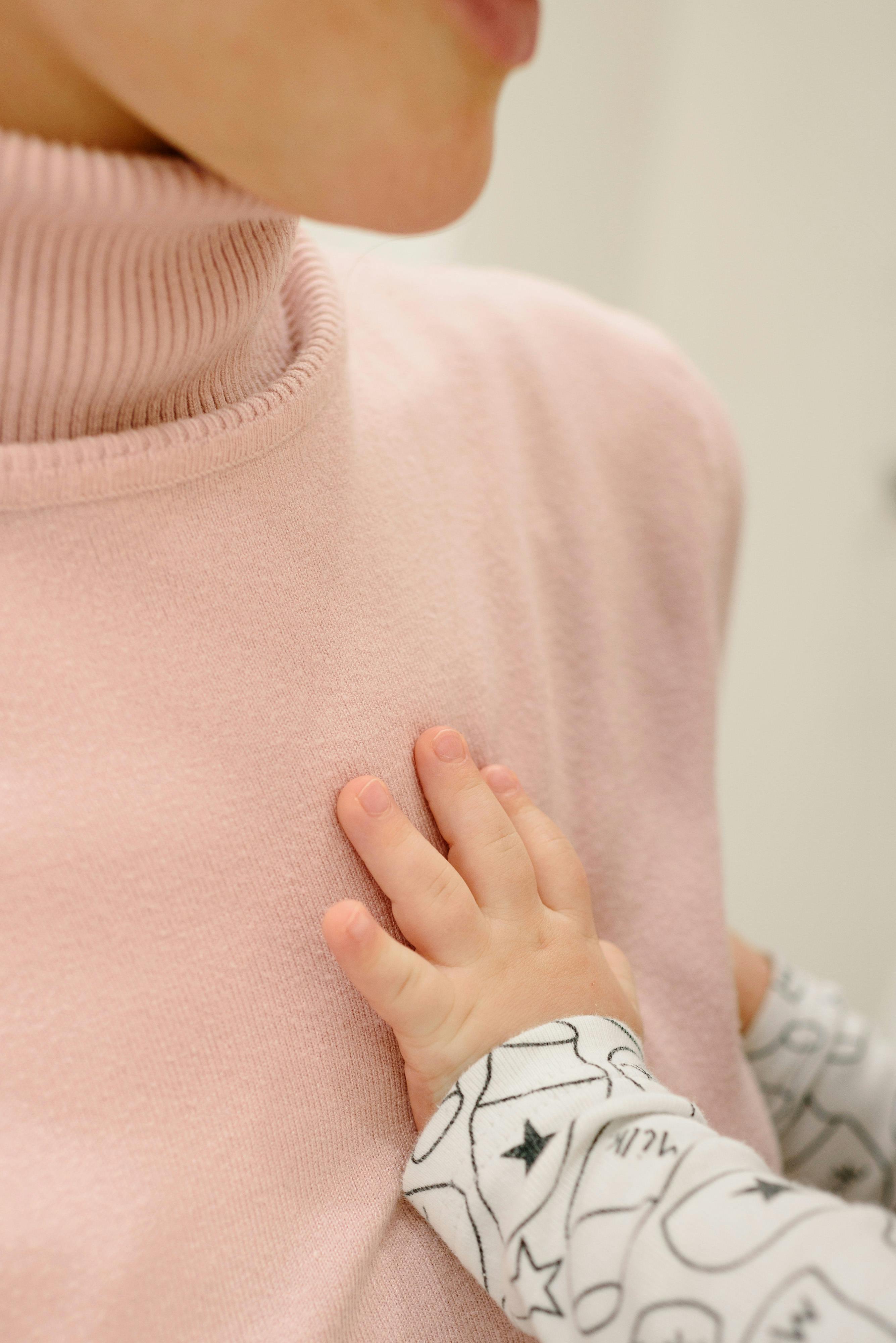 Baby's Hand on Woman's Chest · Free Stock Photo