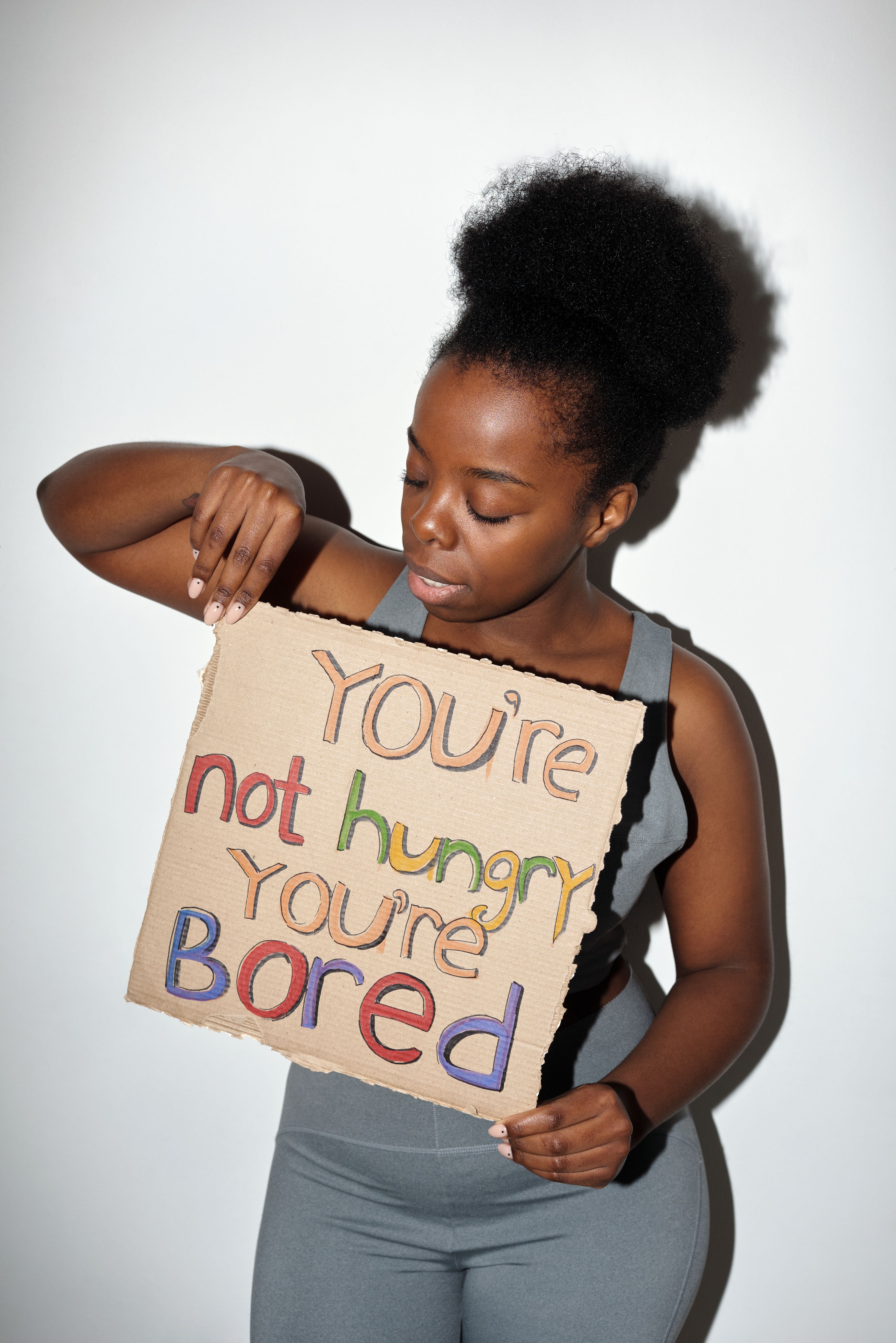 Woman Holding a Sign Youre Not Hungry Youre Bored · Free Stock Photo