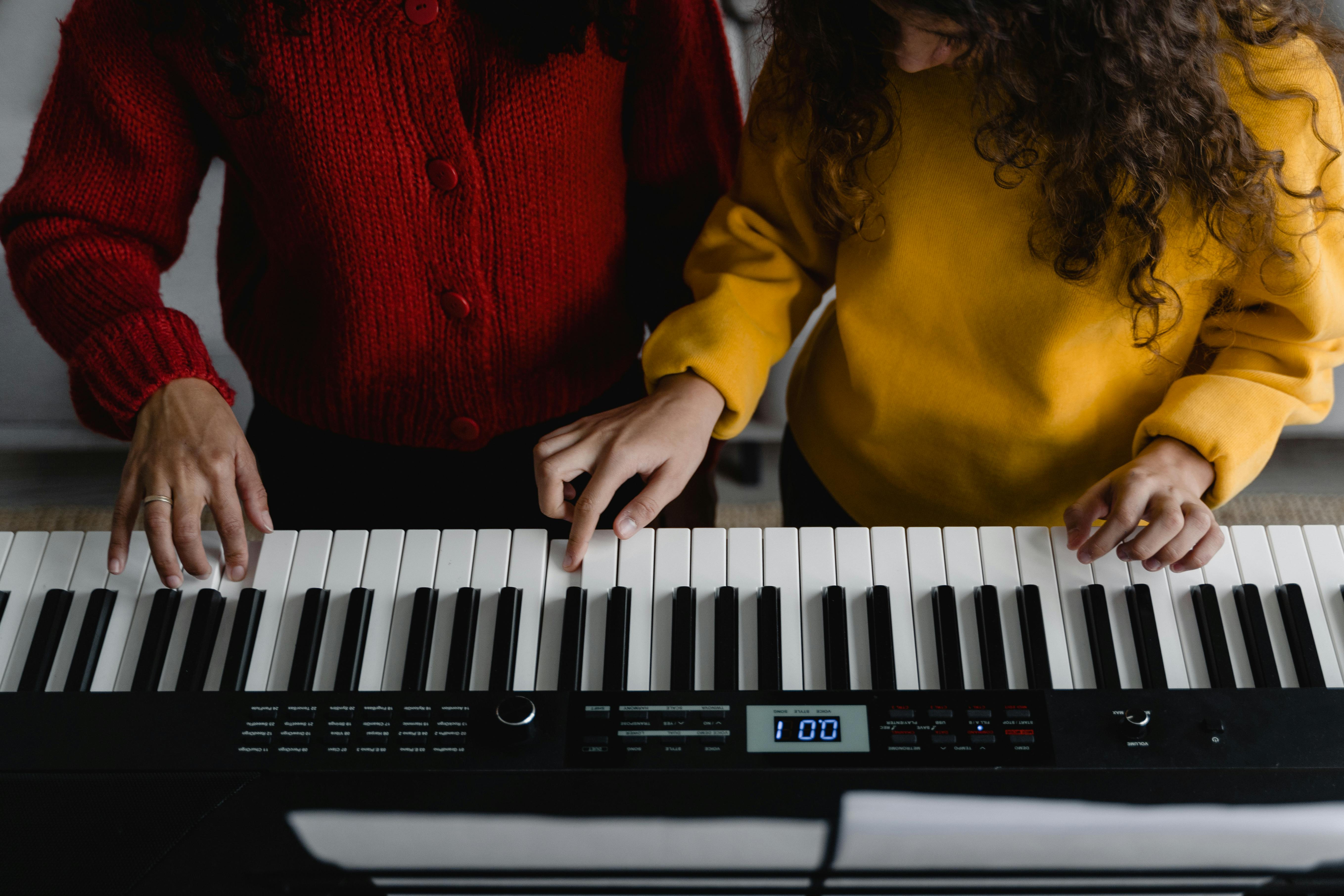 Young Women Standing and Playing an Electronic Keyboard · Free Stock Photo
