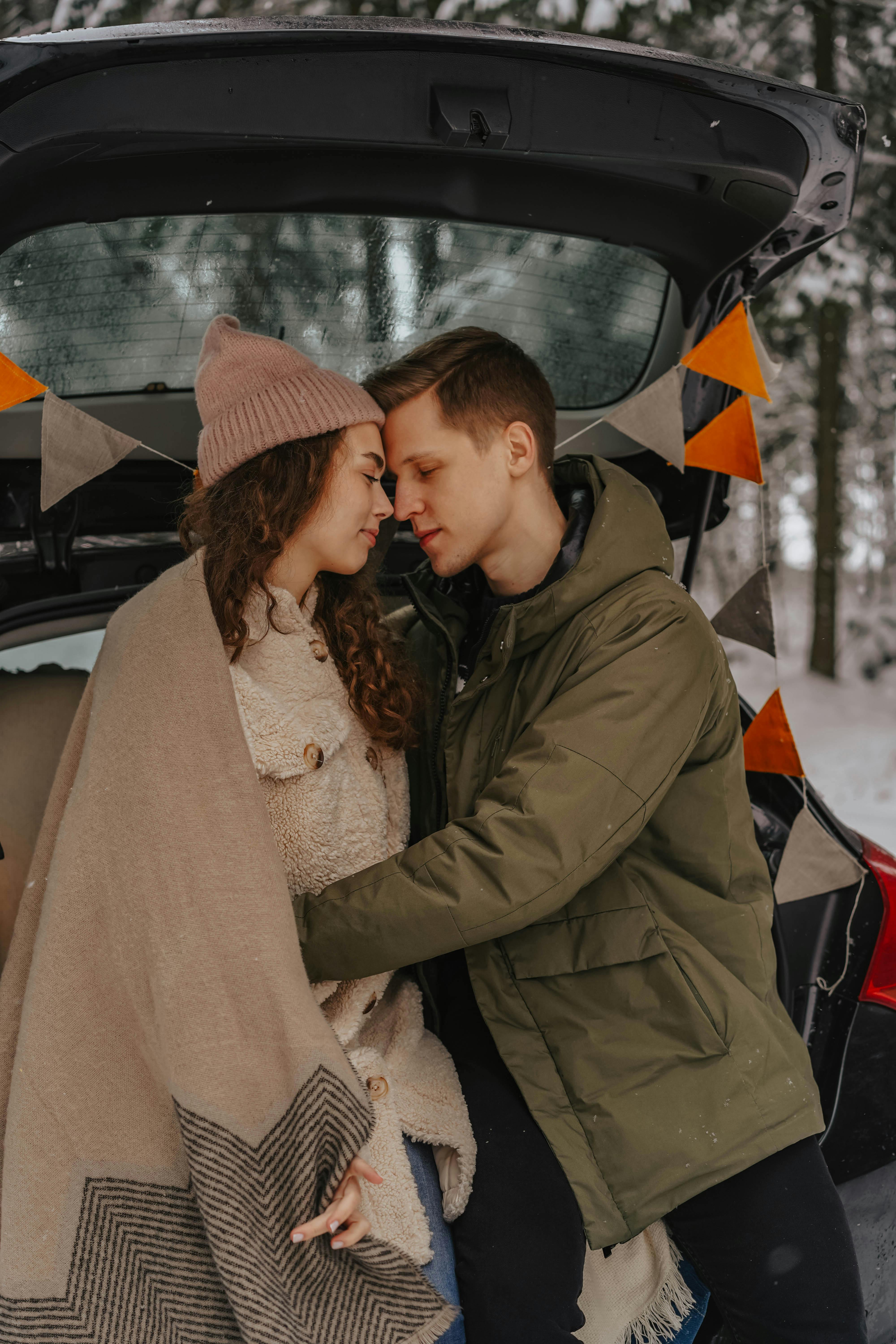 A Couple Hugging while Sitting at the Back of Their Car · Free Stock Photo