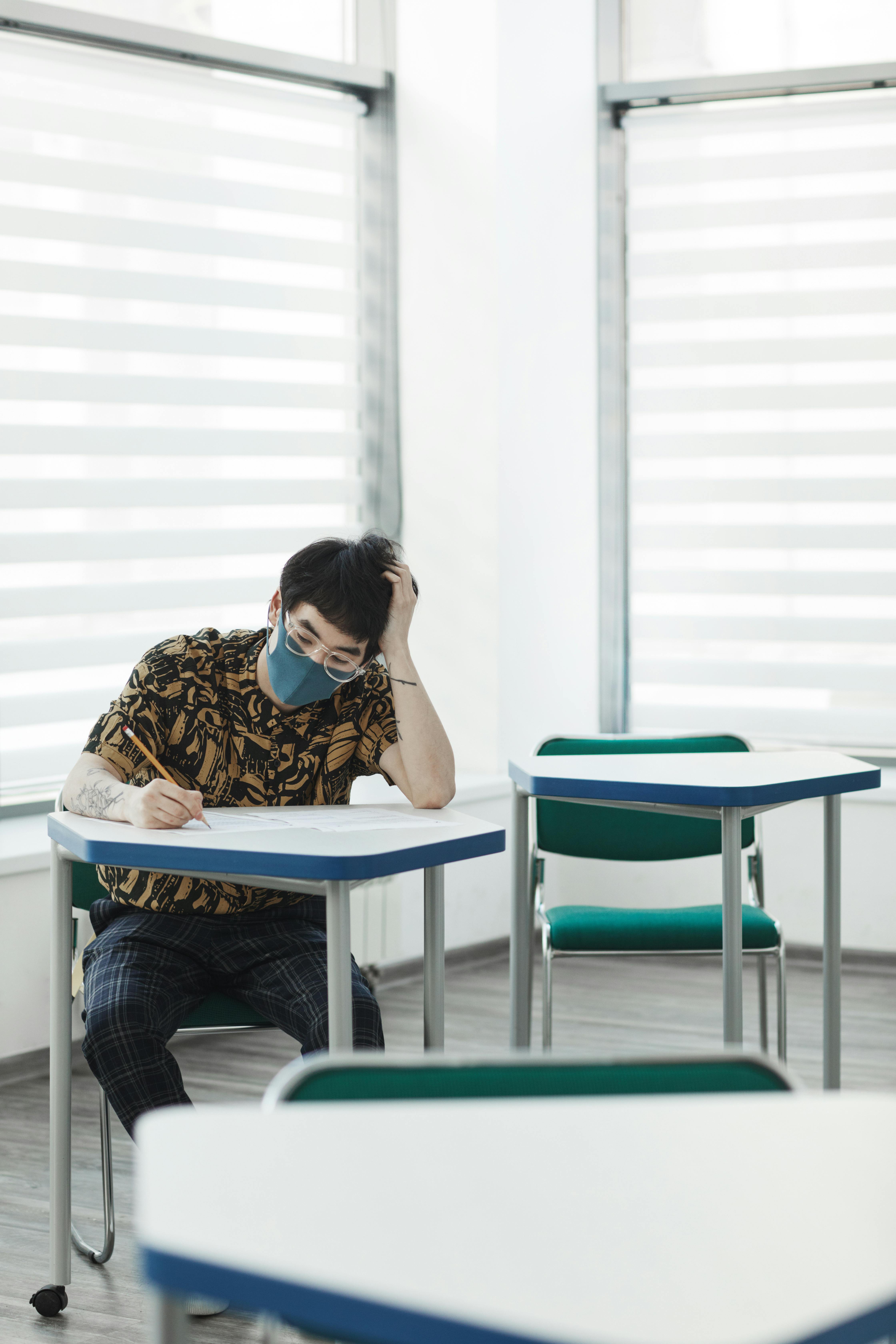 A Man Taking Exam while Wearing Face Mask · Free Stock Photo