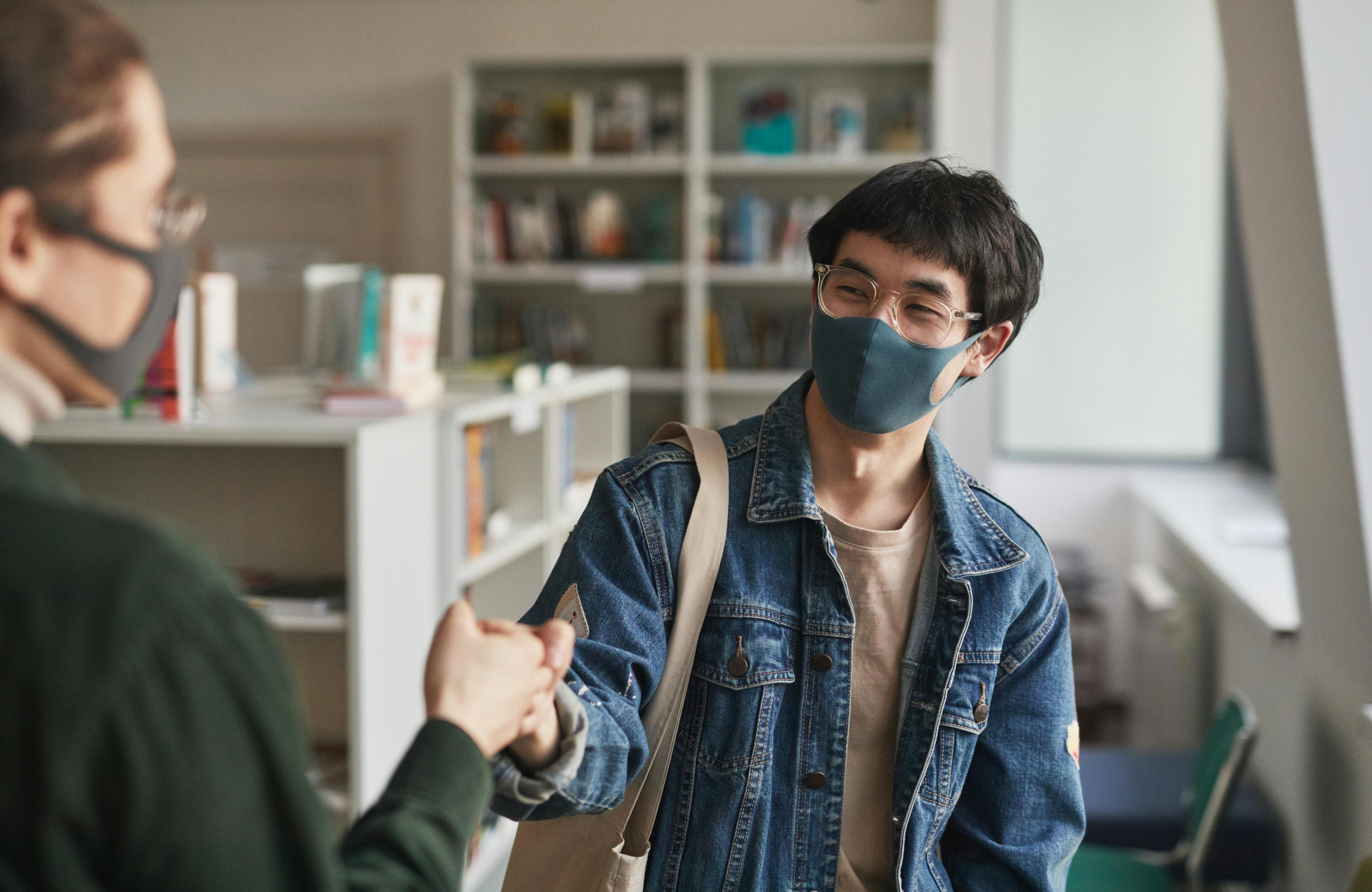Men Wearing Face Masks Fist Bumping · Free Stock Photo