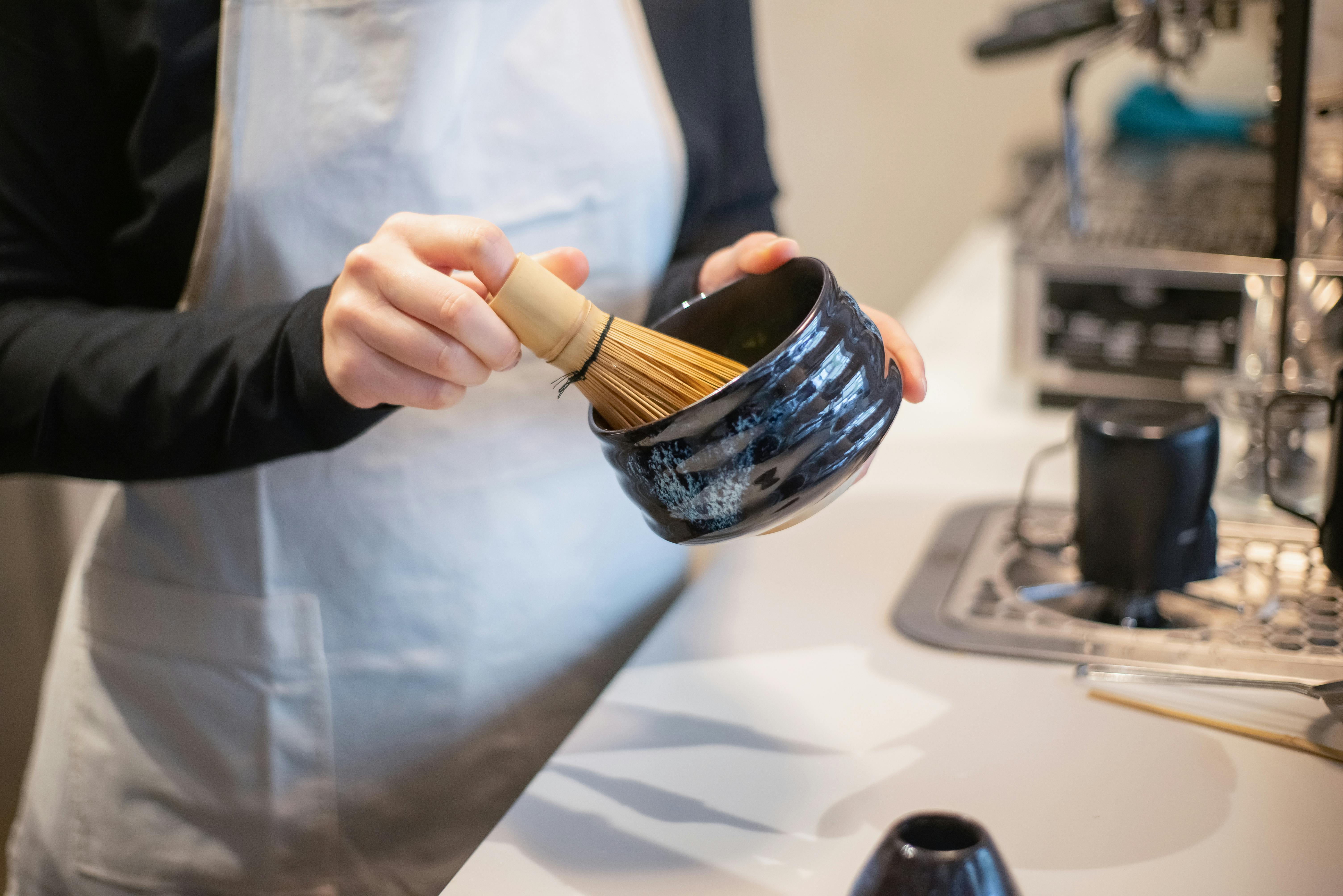 Person Using Bamboo Whisk · Free Stock Photo