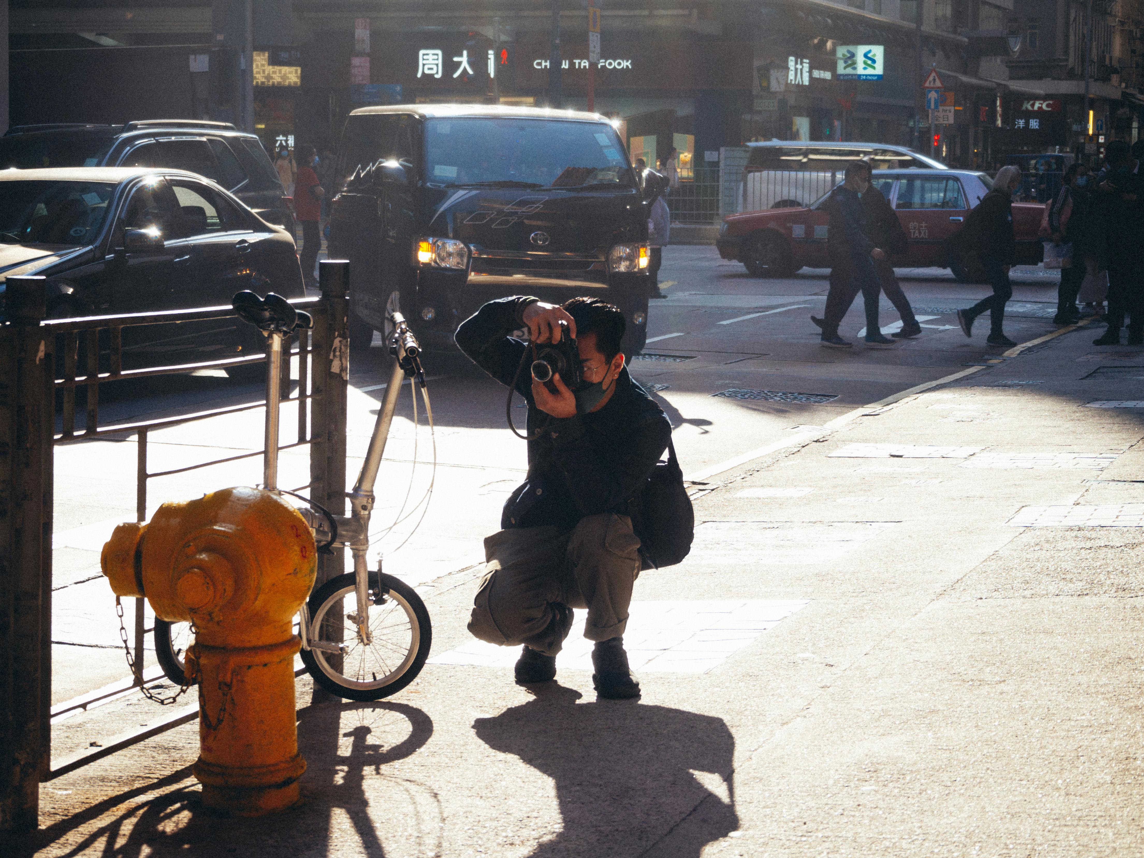 Man in White Long-sleeved Shirt Holding Red Fire Hydrant · Free Stock Photo