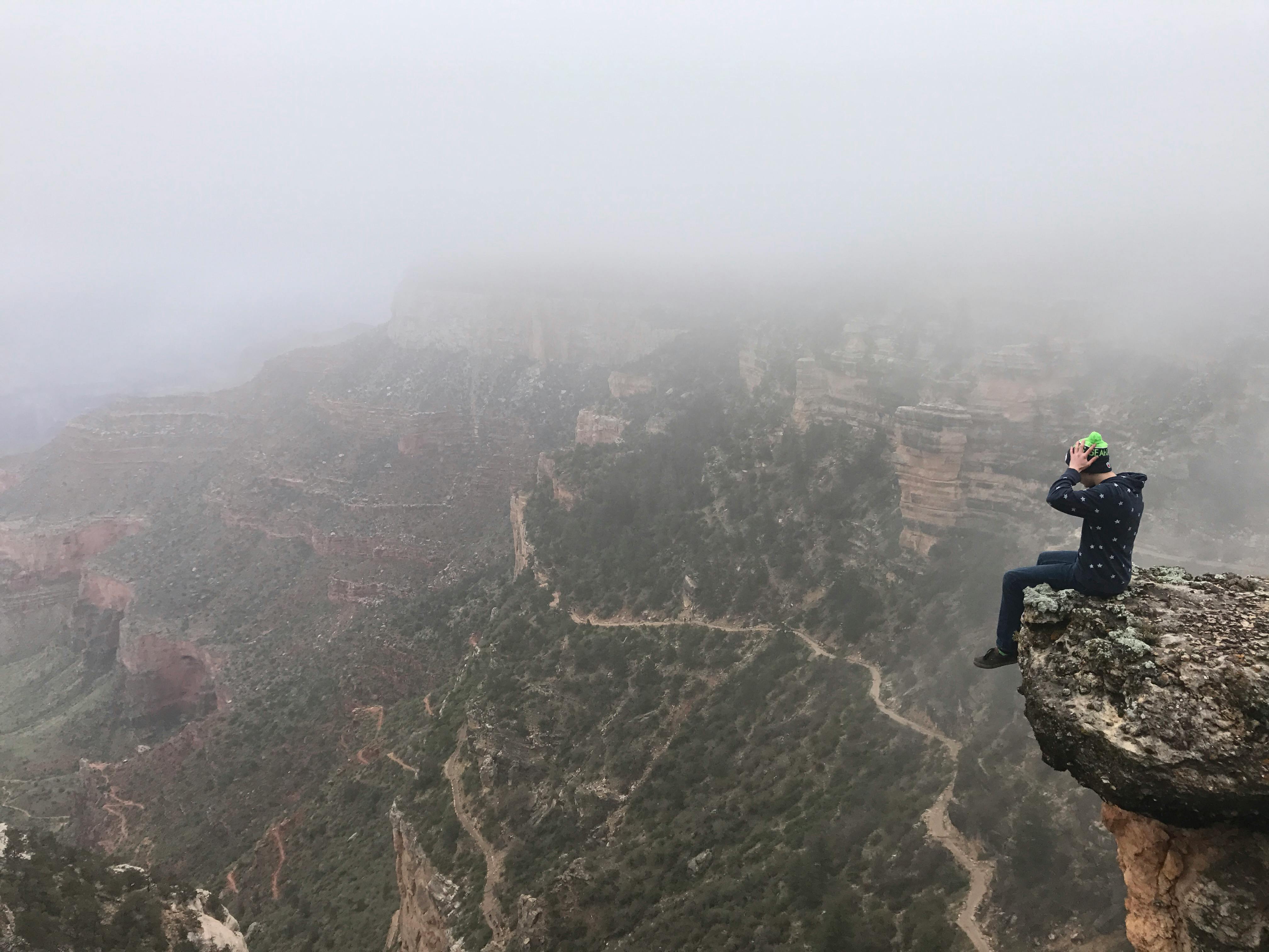 Man Sitting on Top of Cliff on Foggy Mountain · Free Stock Photo Man Sitting on Top of Cliff on Foggy Mountain · Free Stock Photo