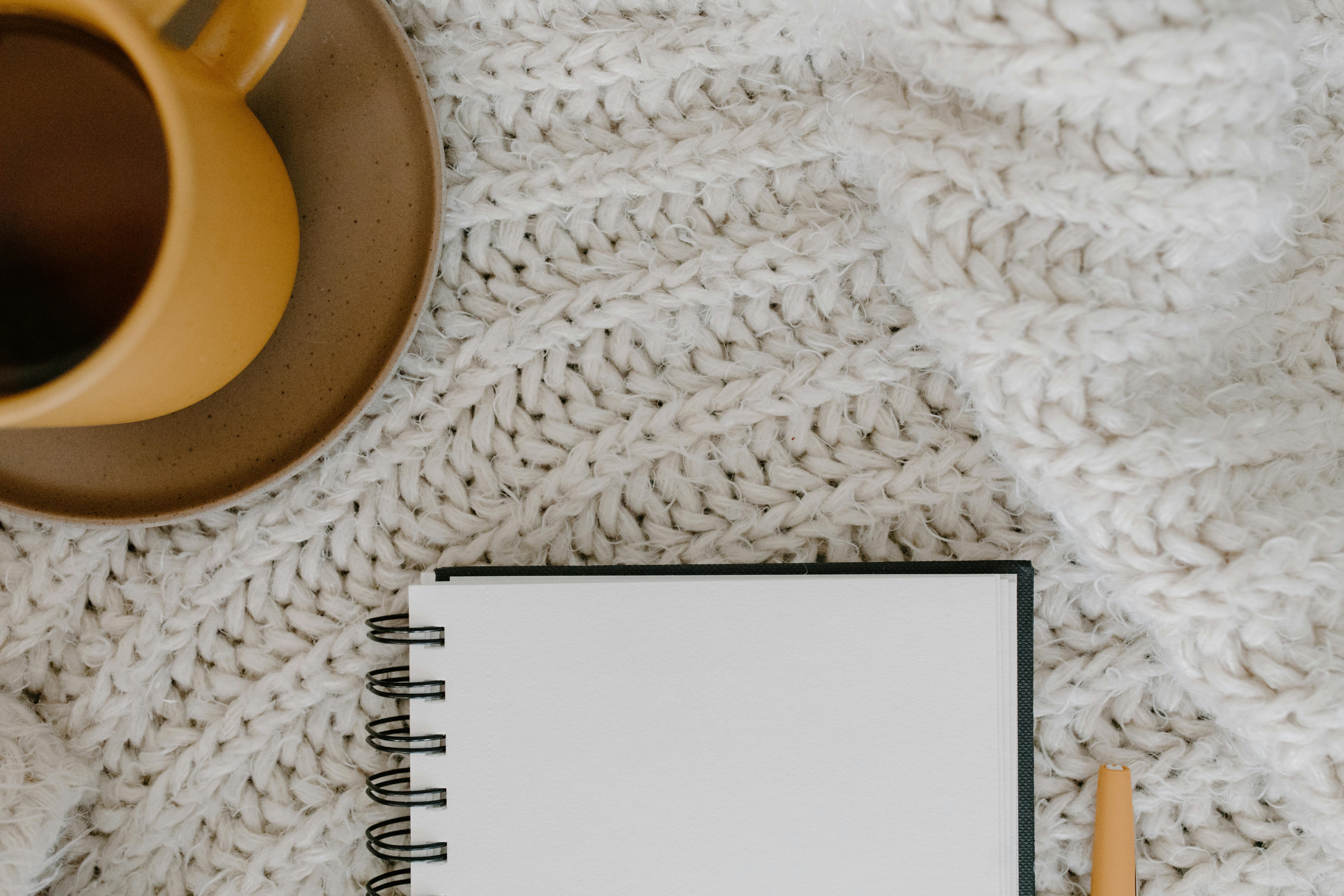 Top View of a Notebook on a Knitted Surface · Free Stock Photo