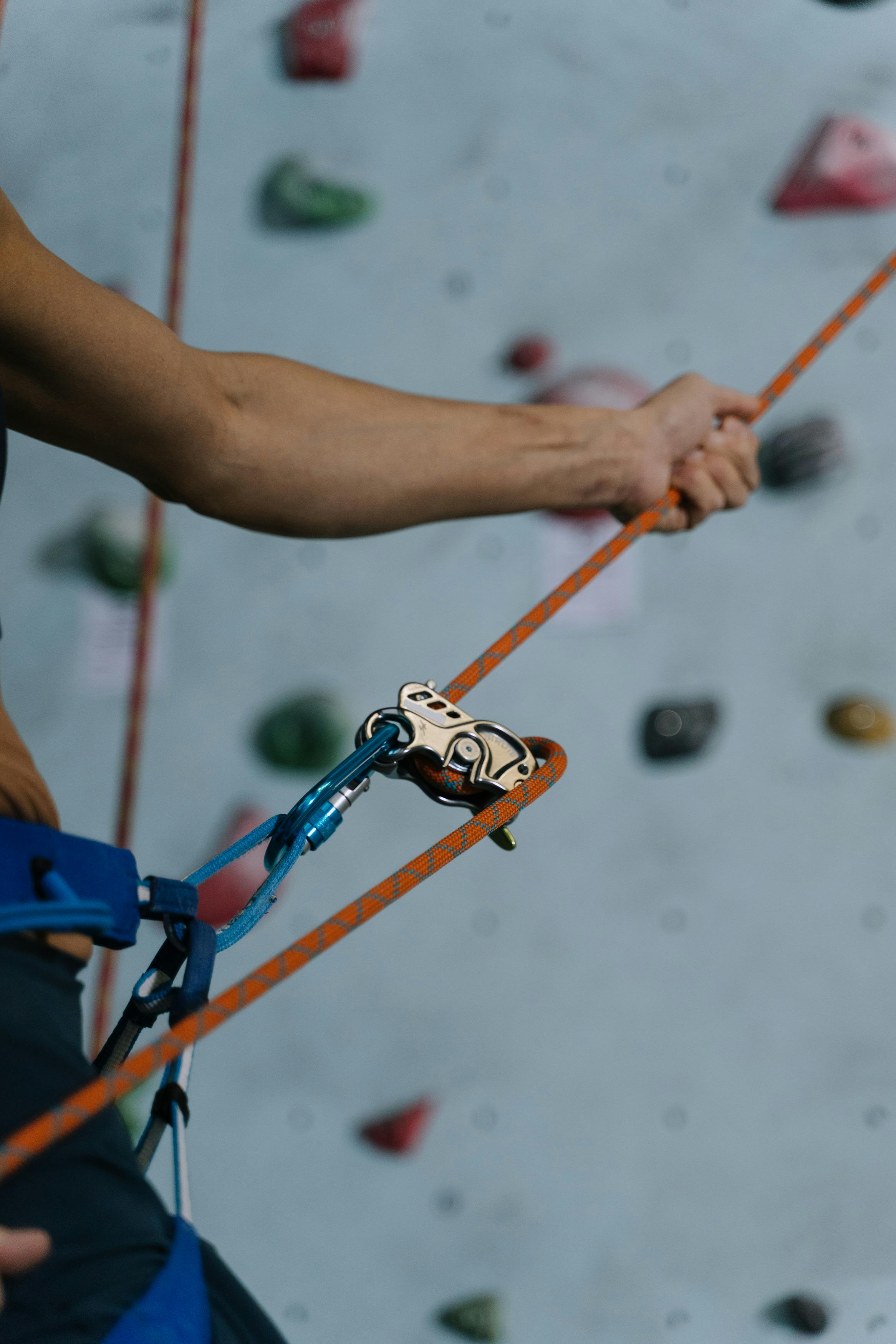 A Person Holding a Rope Attached to a Belay Device · Free Stock Photo