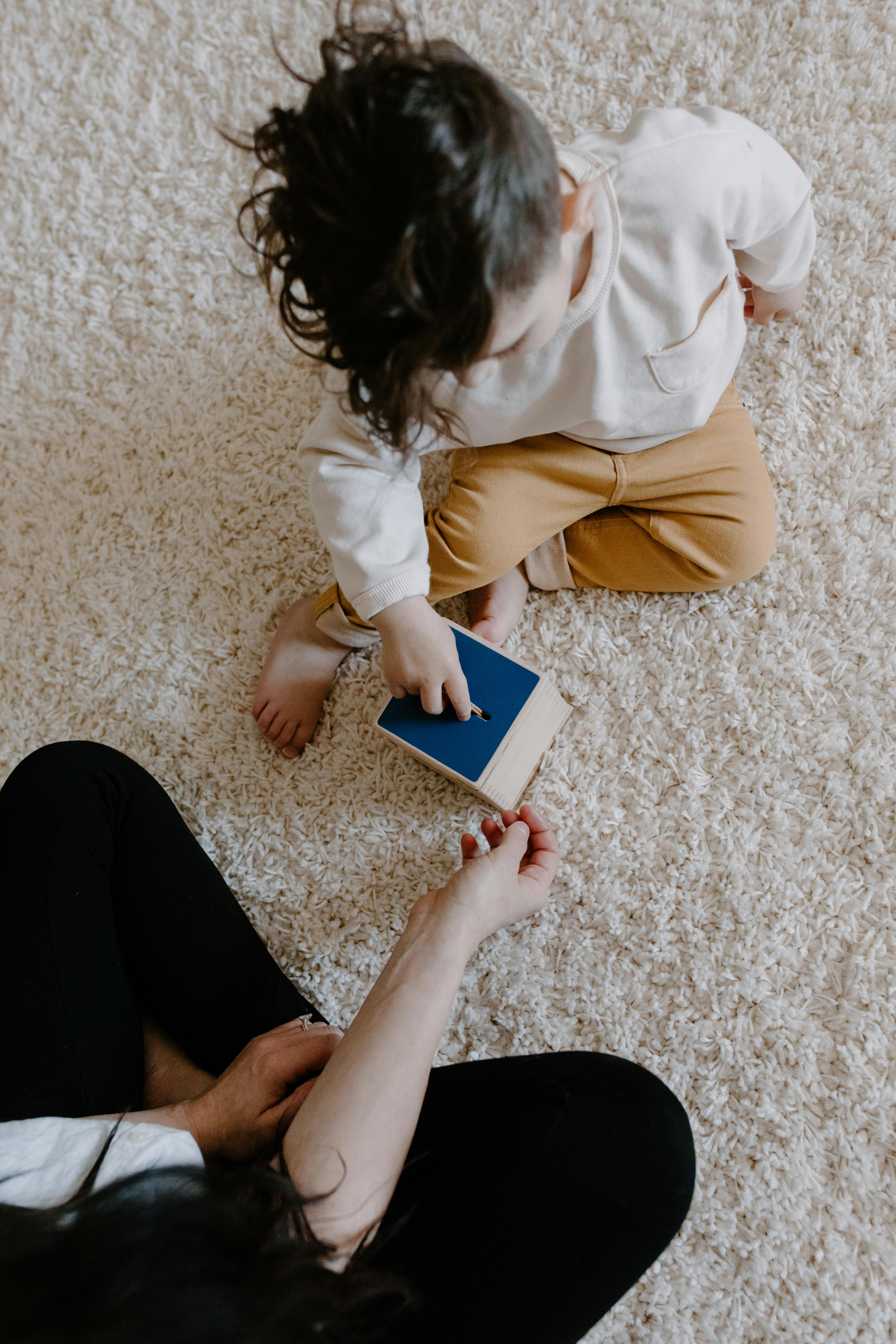 Top View of a Person Handing an Educational Toy to a Child · Free Stock ...