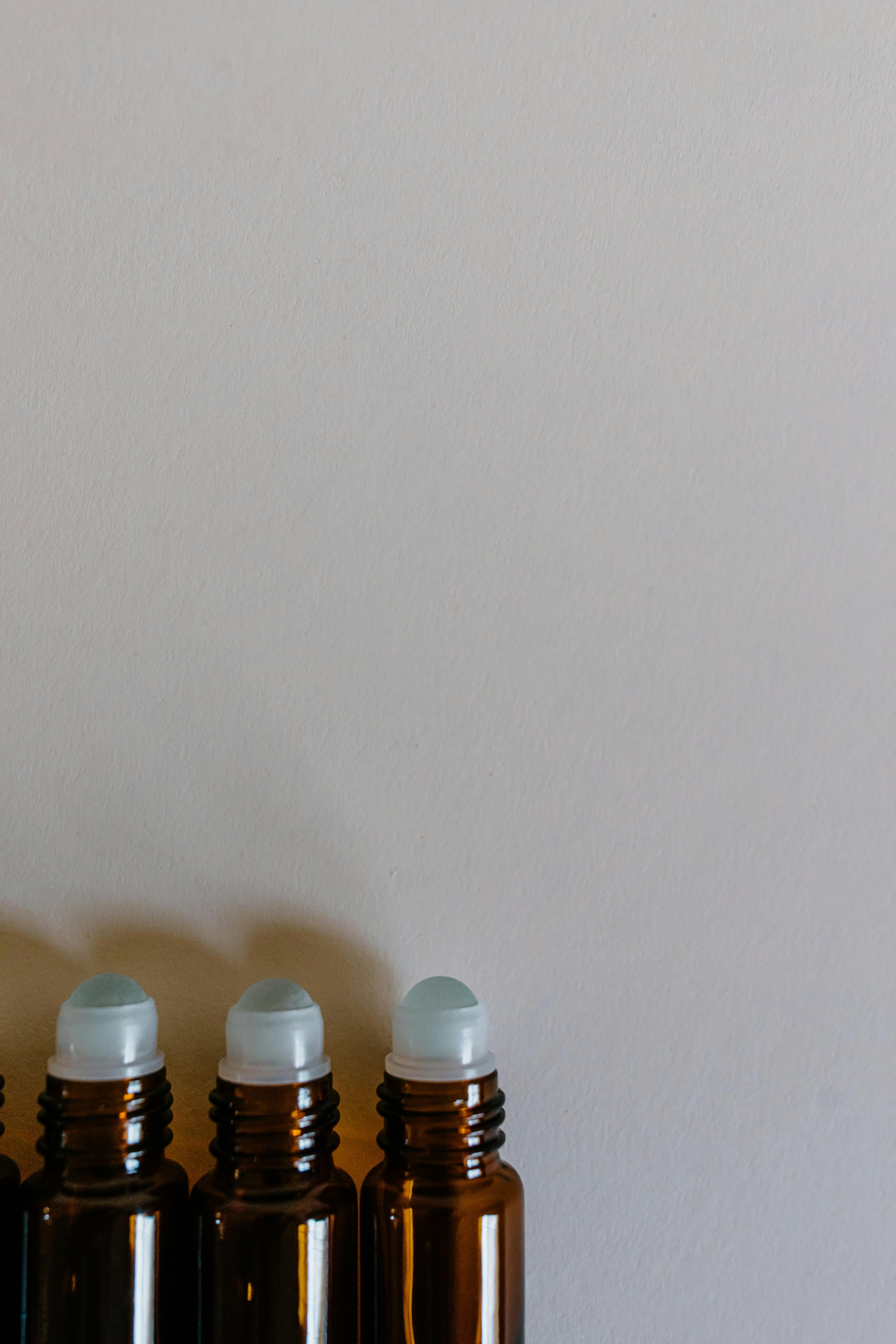 Close-Up Shot of Essential Oil Bottles on White Surface · Free Stock Photo