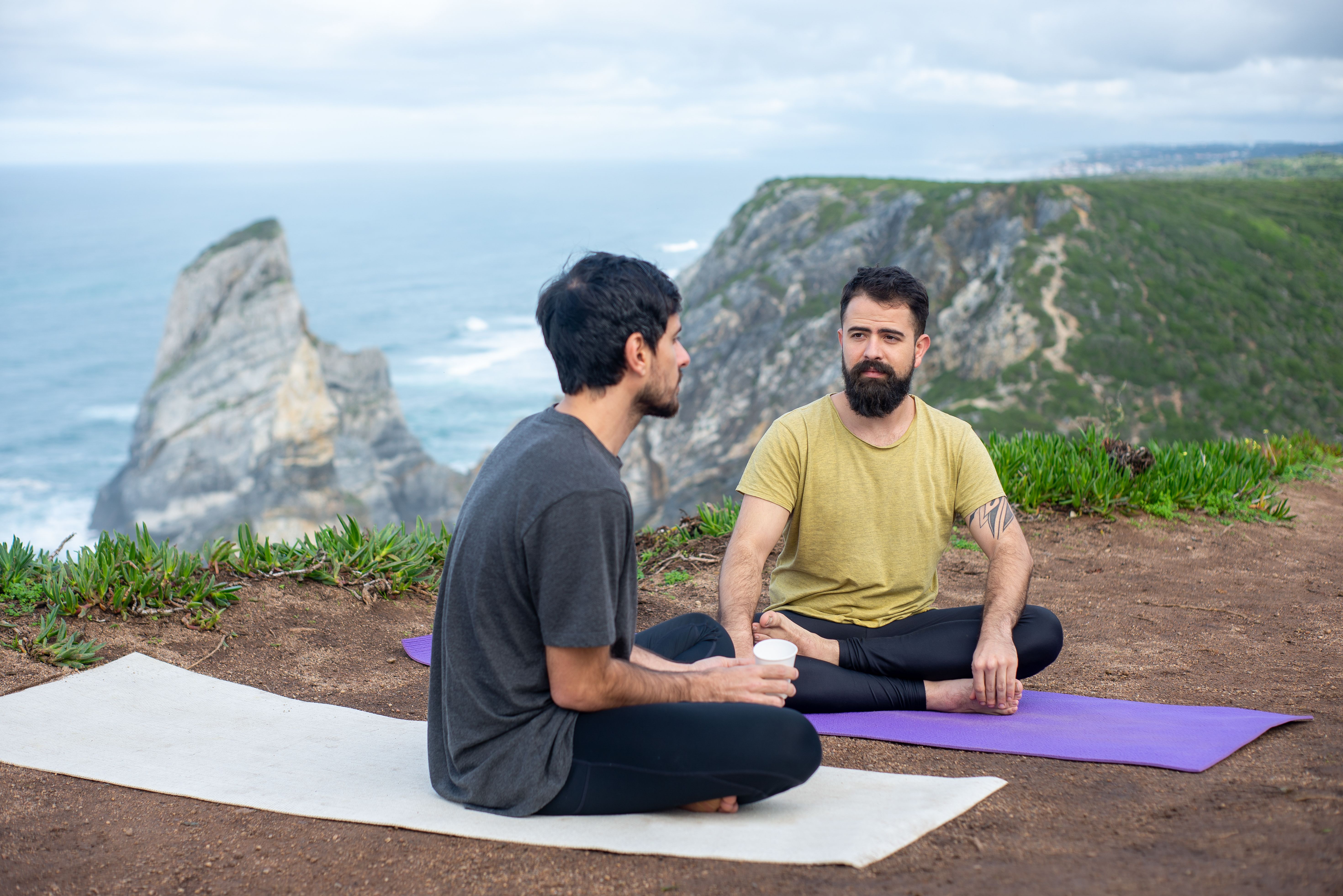 Men Sitting on Yoga Mats on a Cliff · Free Stock Photo