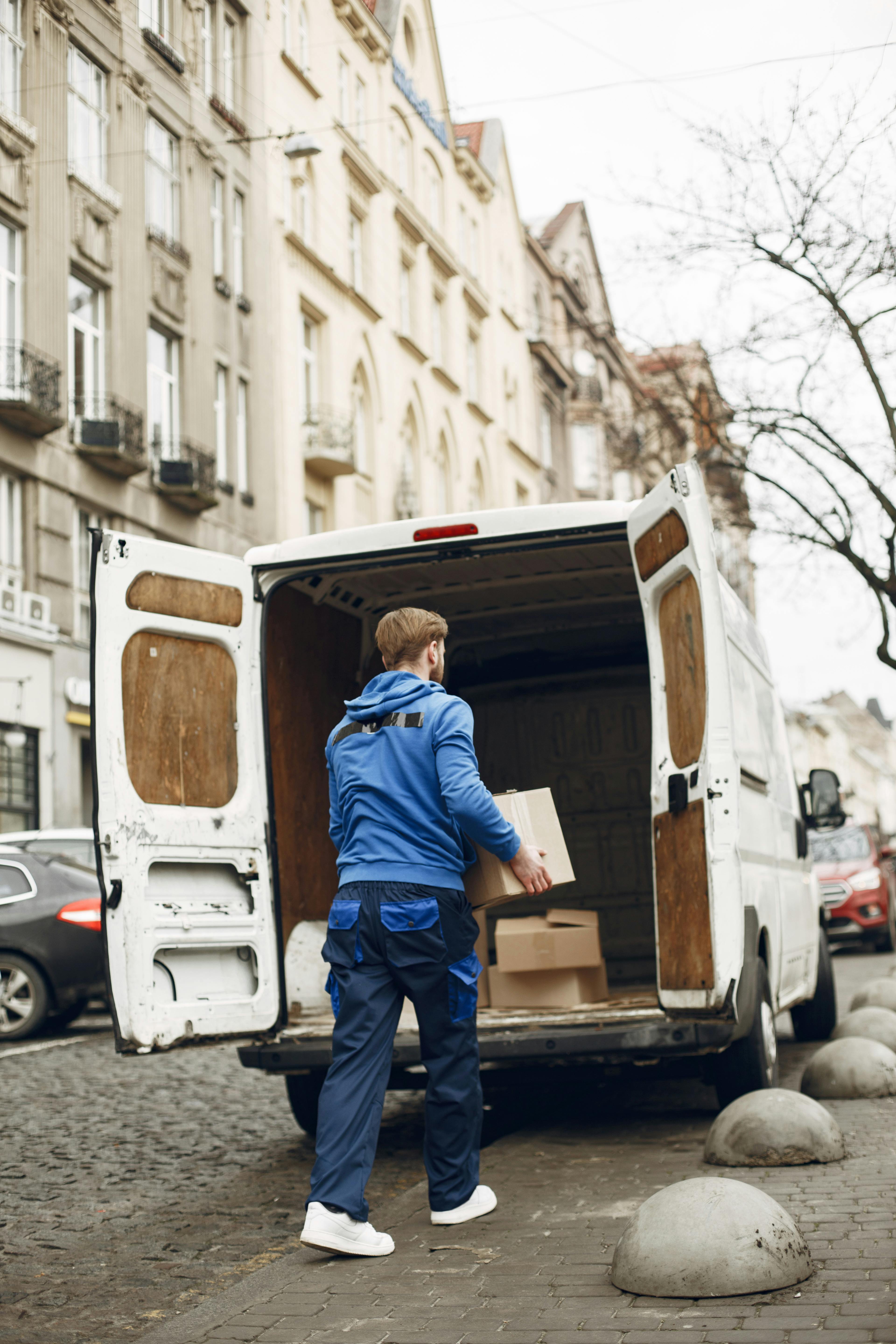 Man Stacking Boxes in a Van · Free Stock Photo