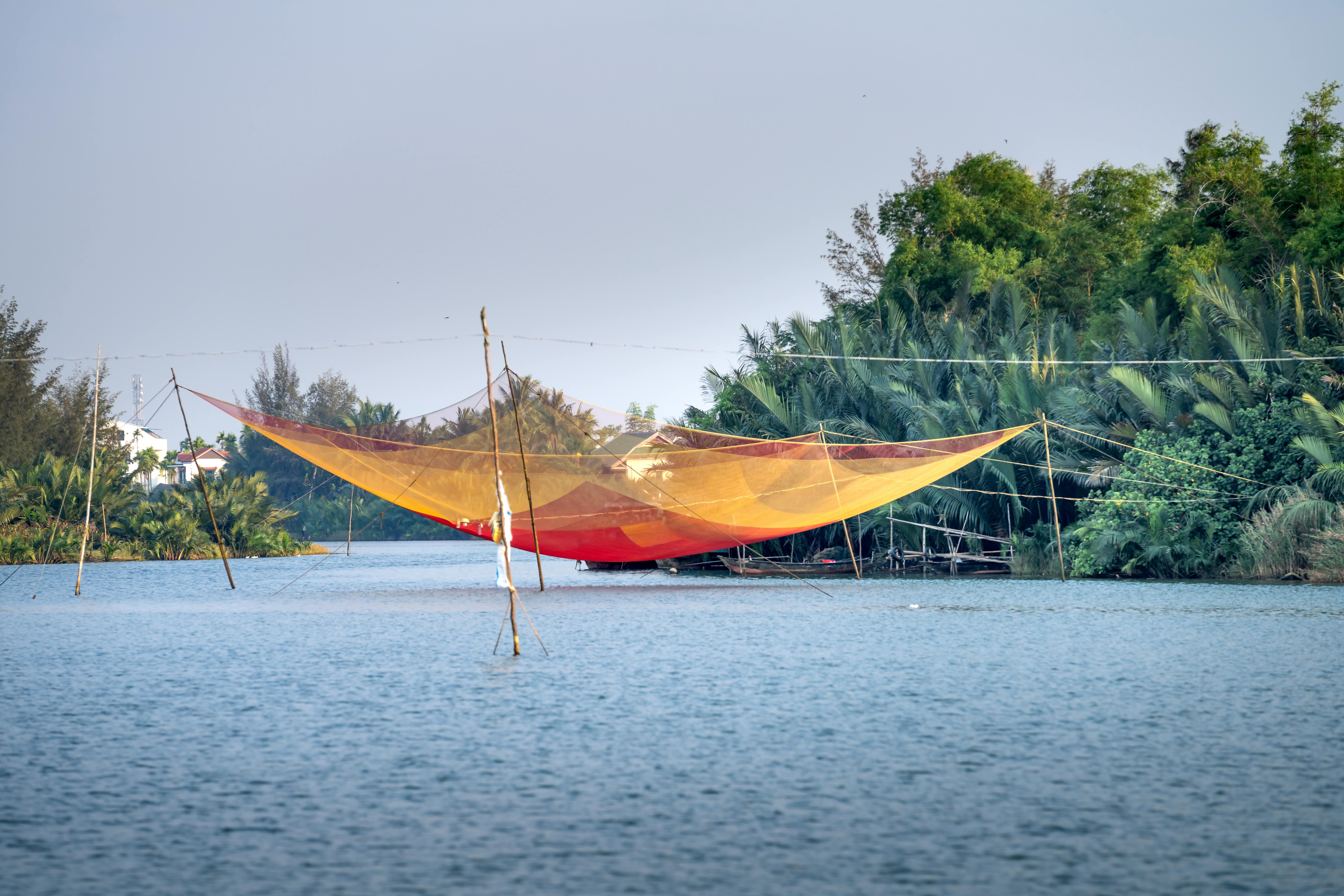 Traditional lift fishing net over river near tropical forest in Vietnam ...