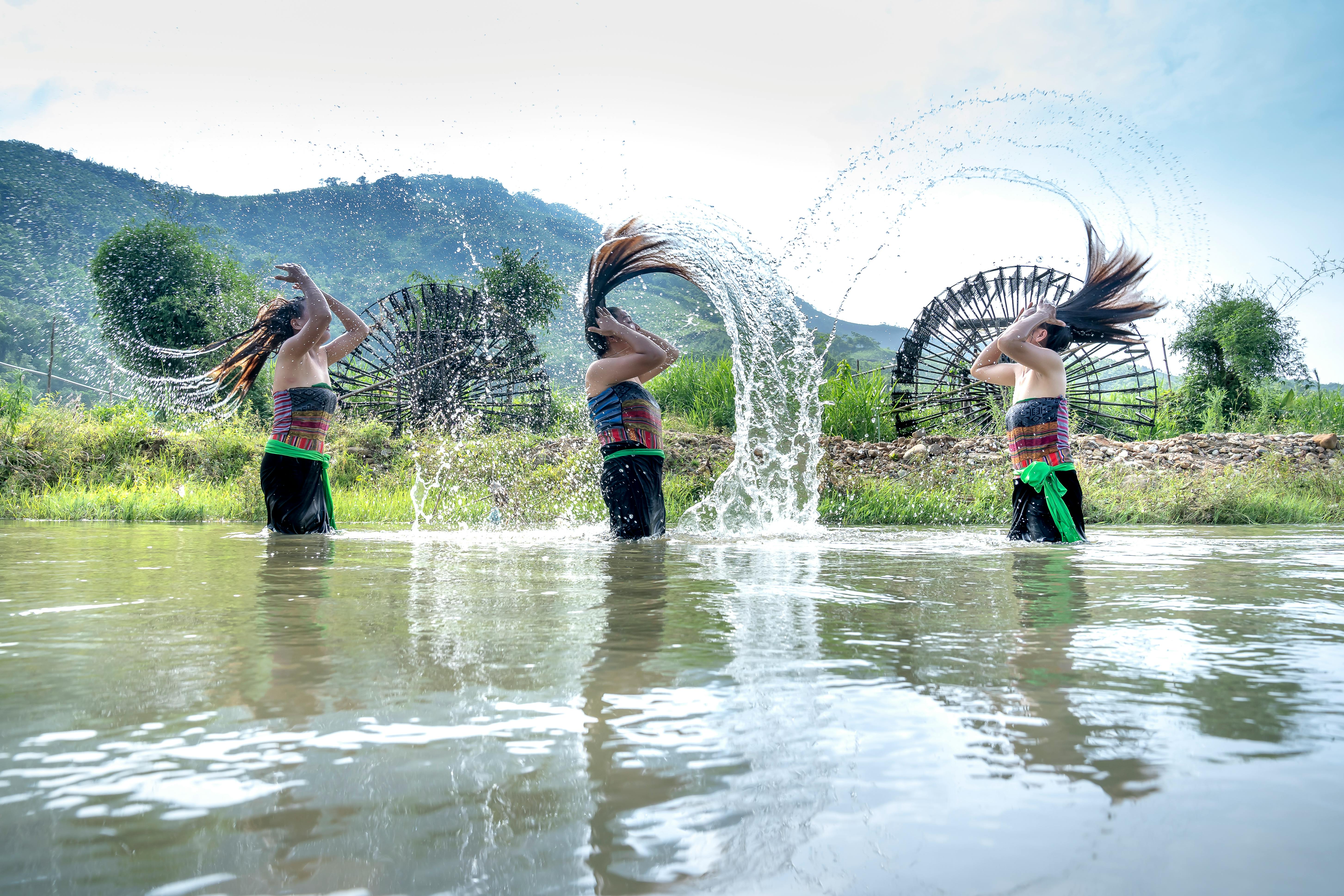 Women shaking hair while washing in river · Free Stock Photo