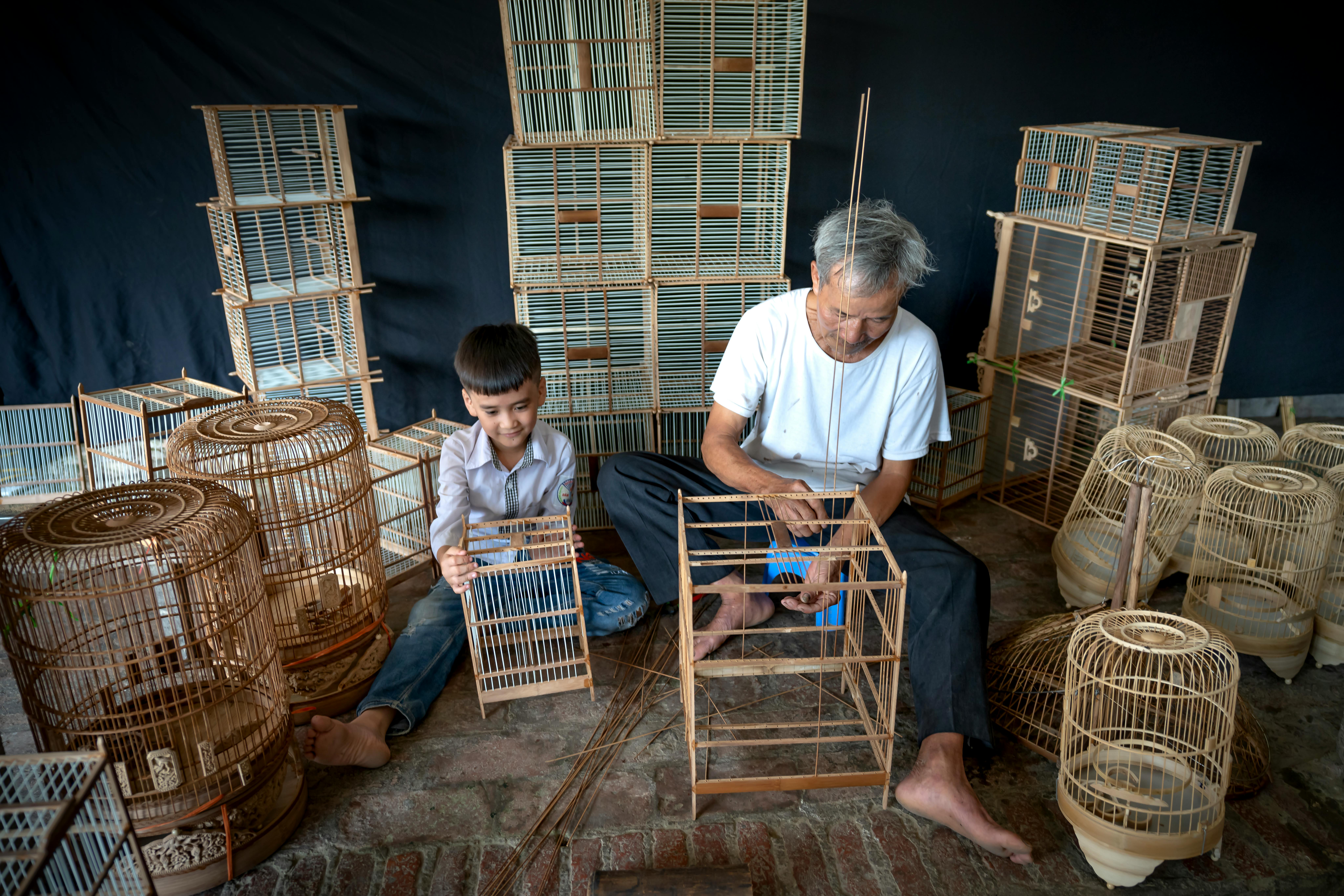 Senior workman and boy making cages in workshop · Free Stock Photo