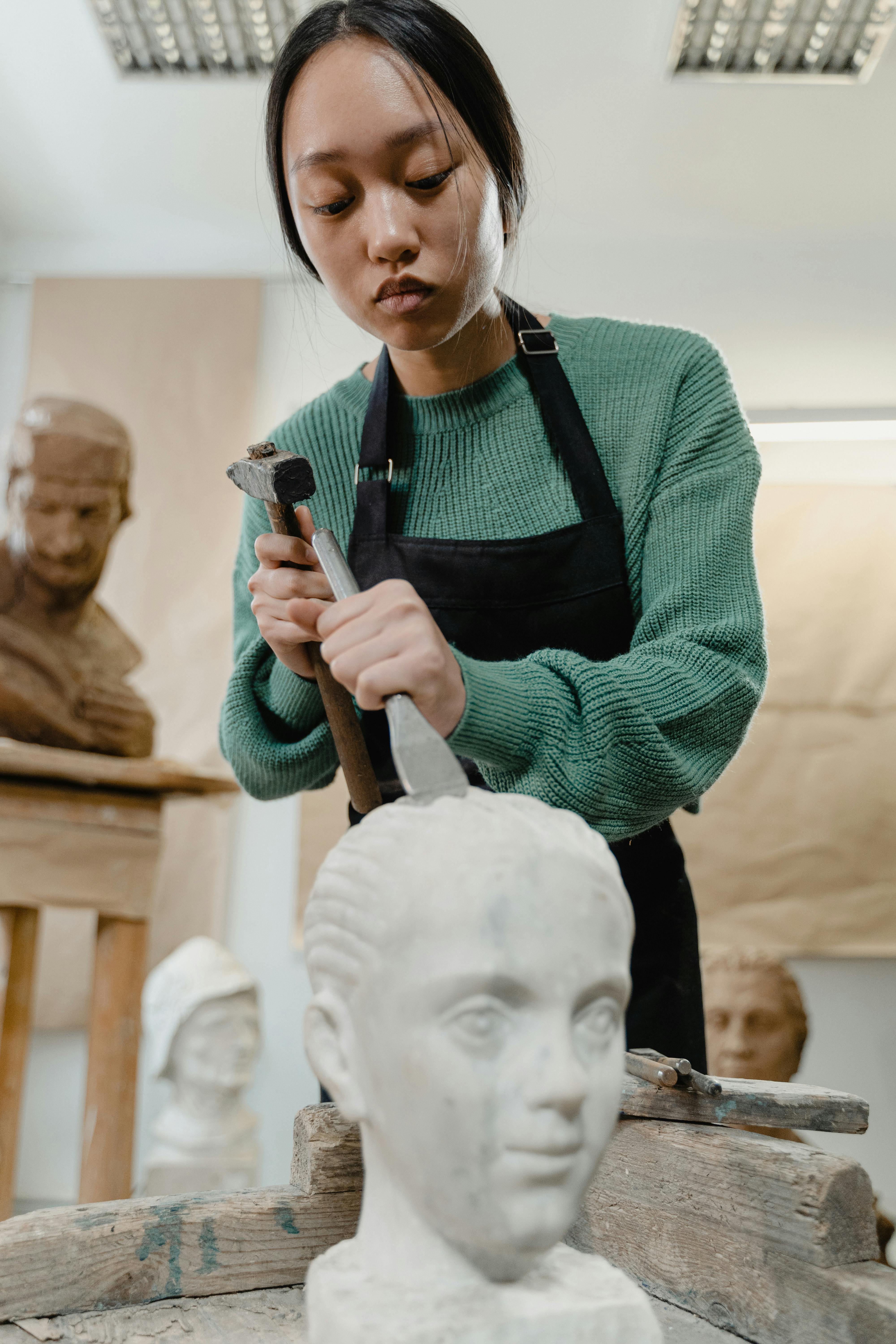 A Woman Using a Hammer a Chisel · Free Stock Photo