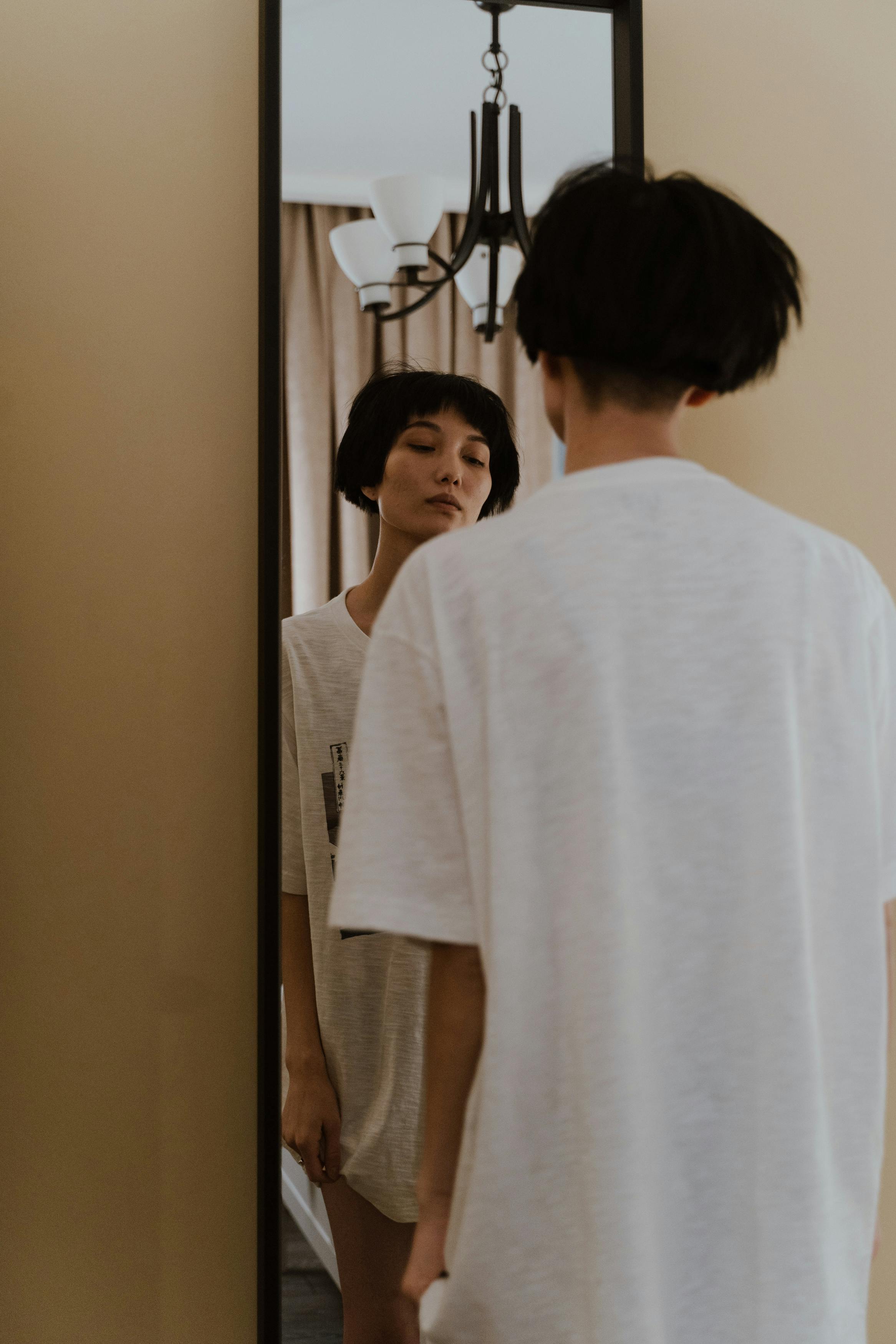 Back View of a Woman Looking in a Mirror · Free Stock Photo