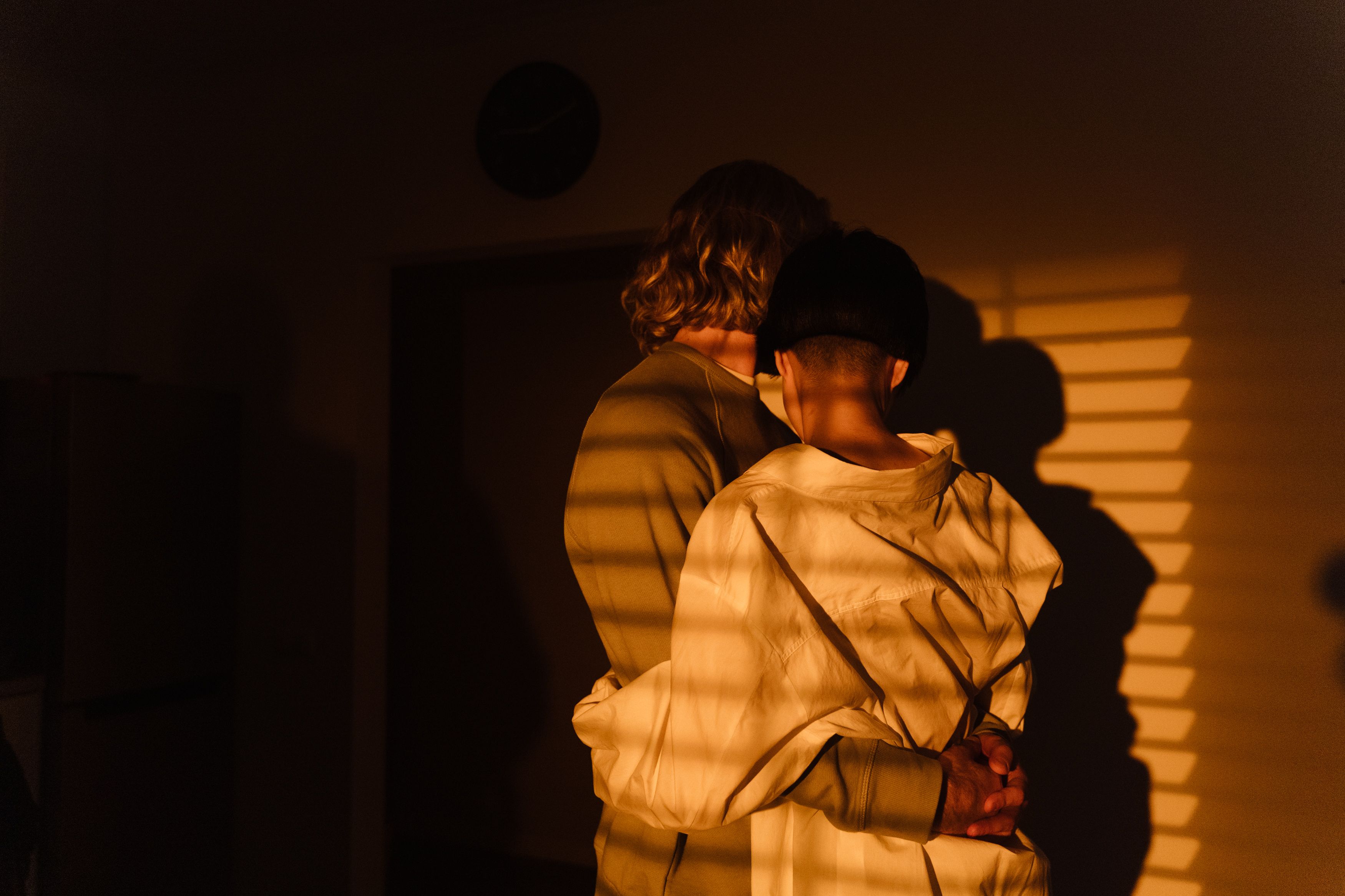 Couple Hugging and Standing in the Light of a Setting Sun in a Room ...