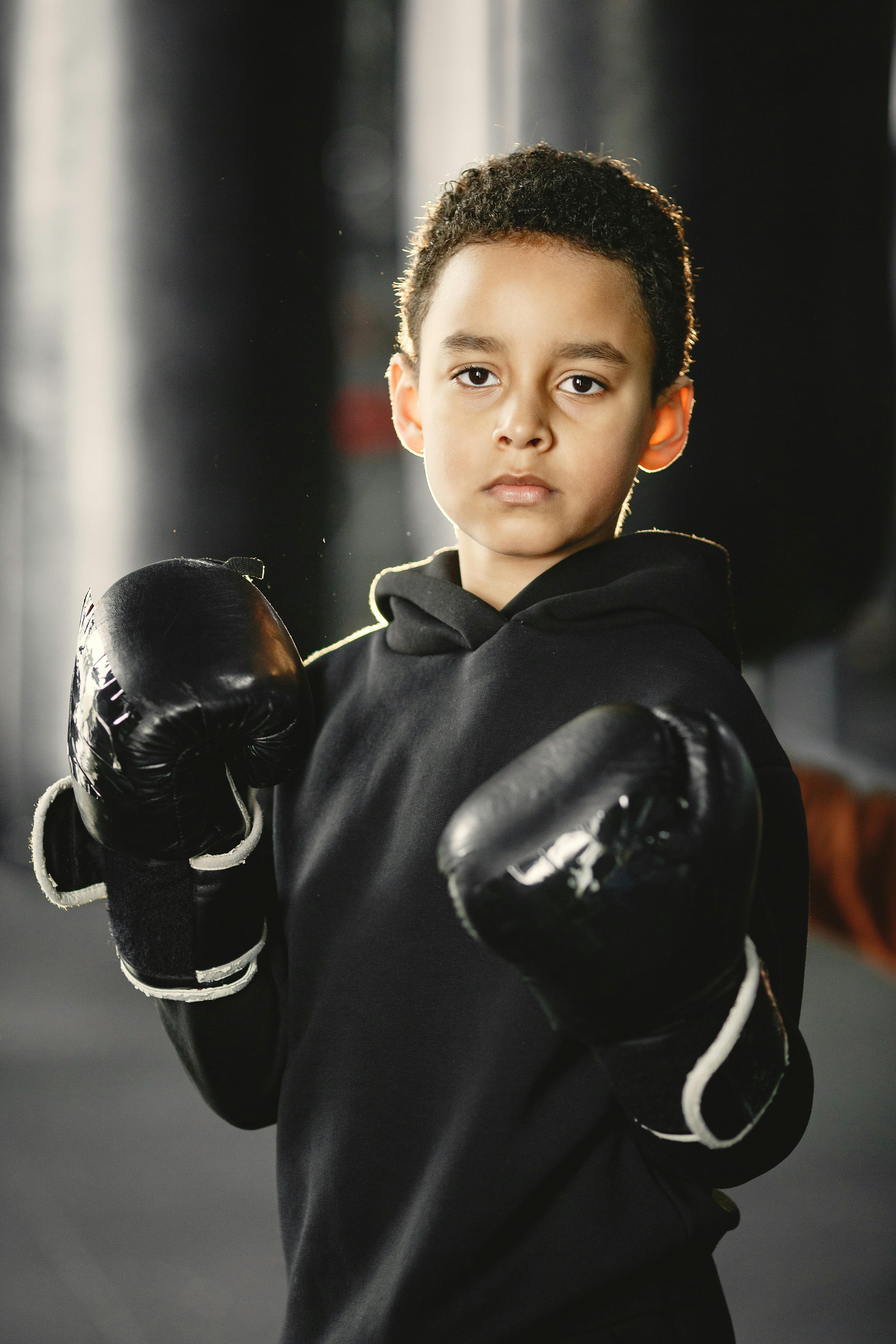A Boy Wearing Black Leather Boxing Gloves · Free Stock Photo