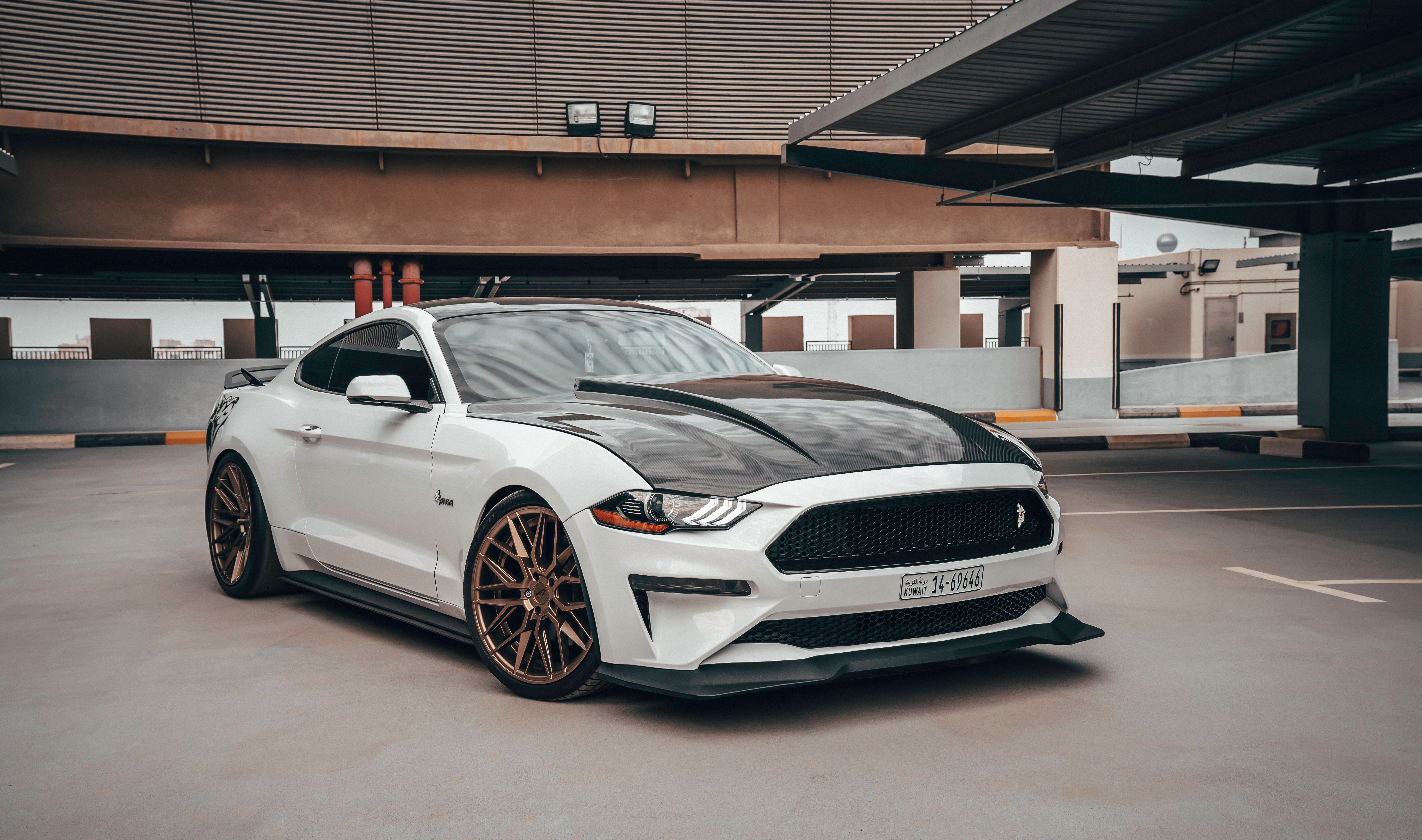 White Ford Mustang Parked Near Brown Building · Free Stock Photo