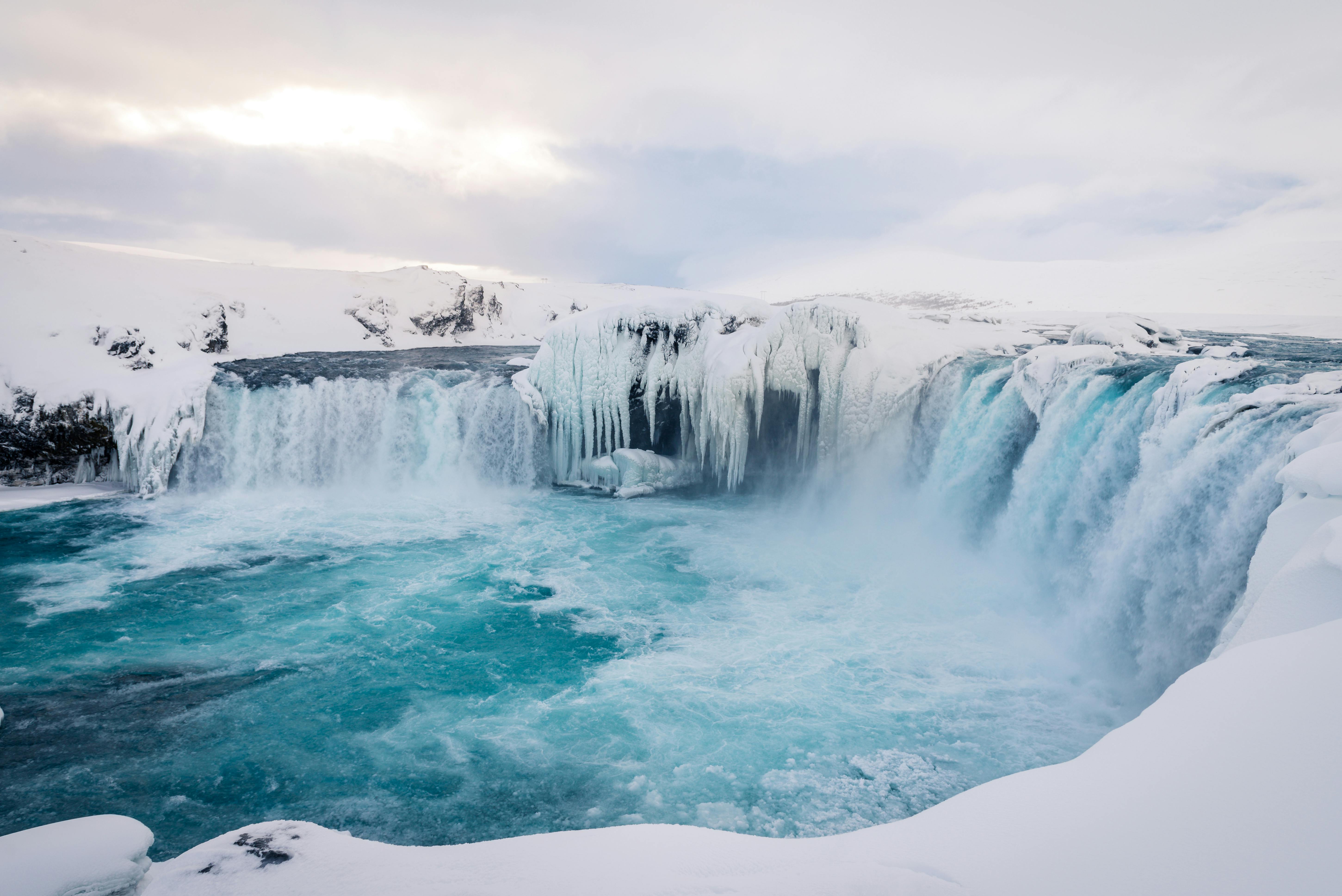 Waterfalls Surrounded by the Snow Under White Cloudy Sky · Free Stock Photo