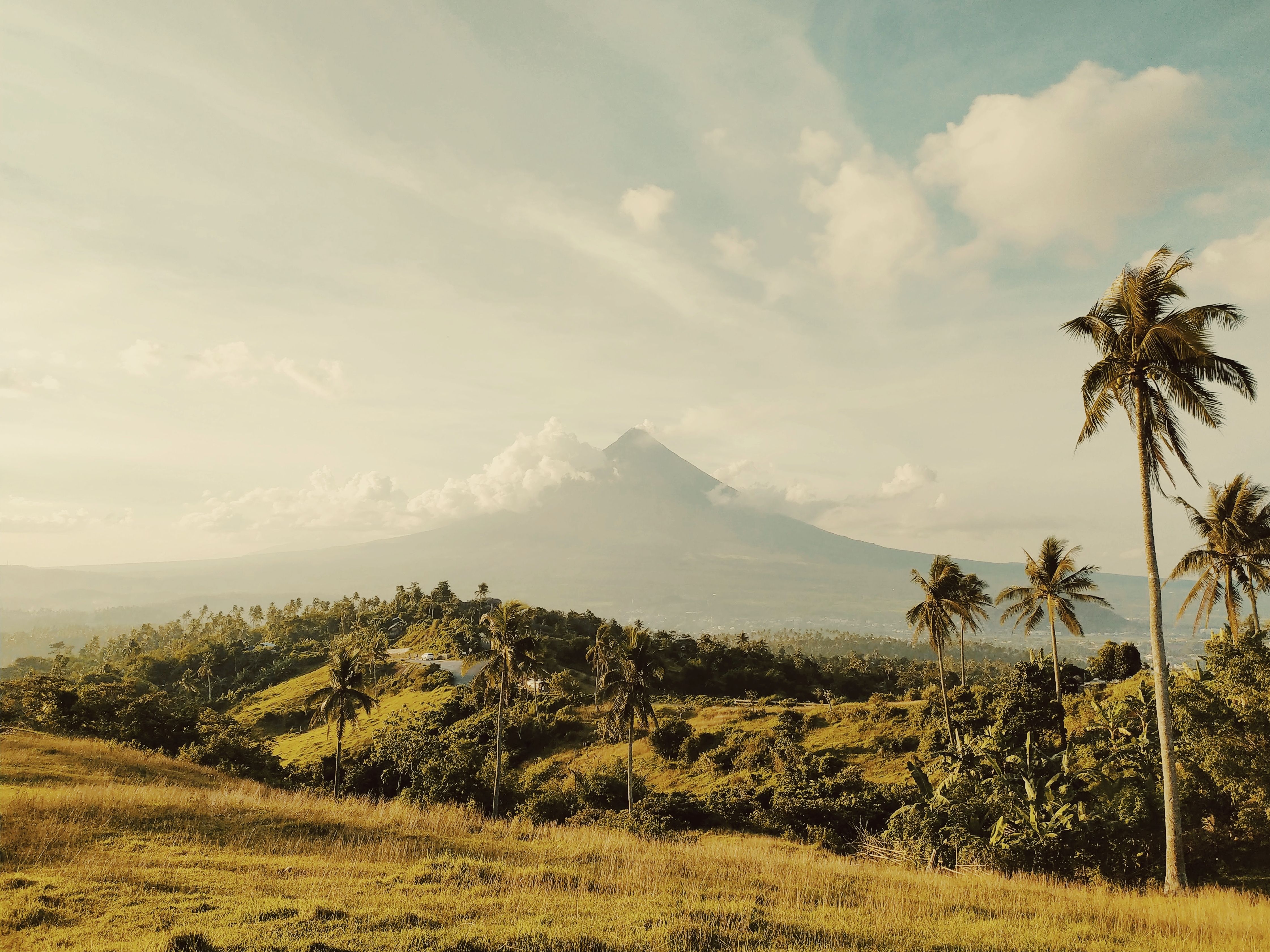 Green Grass Field Near Mountain Under White Clouds · Free Stock Photo