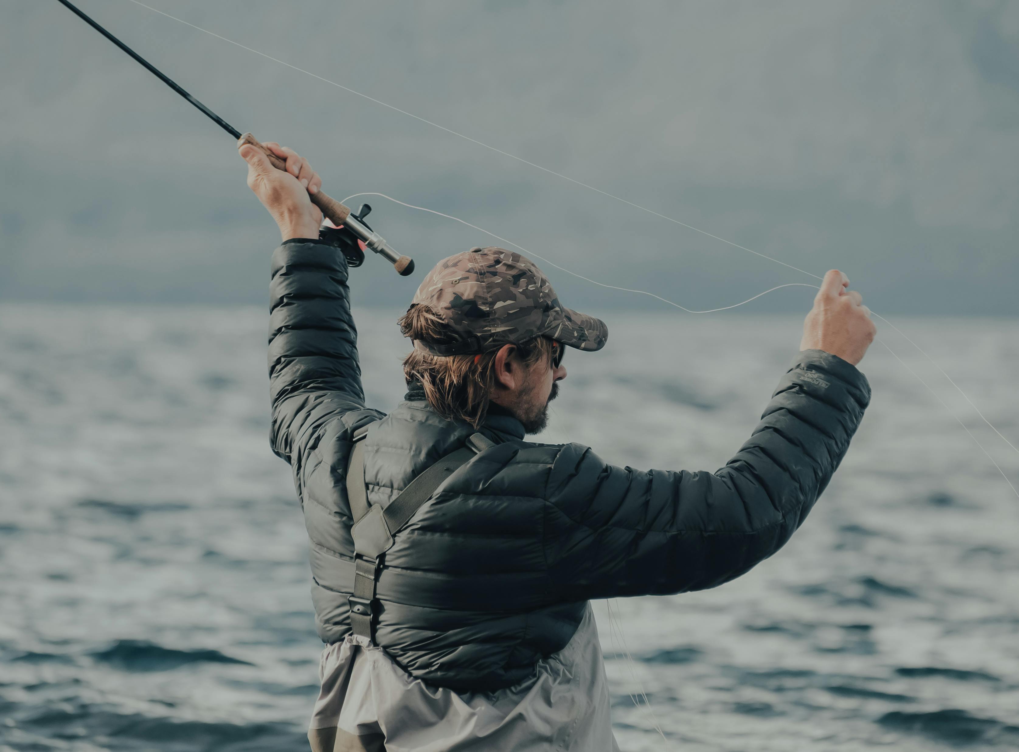 Man in Black Jacket and Brown Pants Holding Black Fishing Rod · Free ...