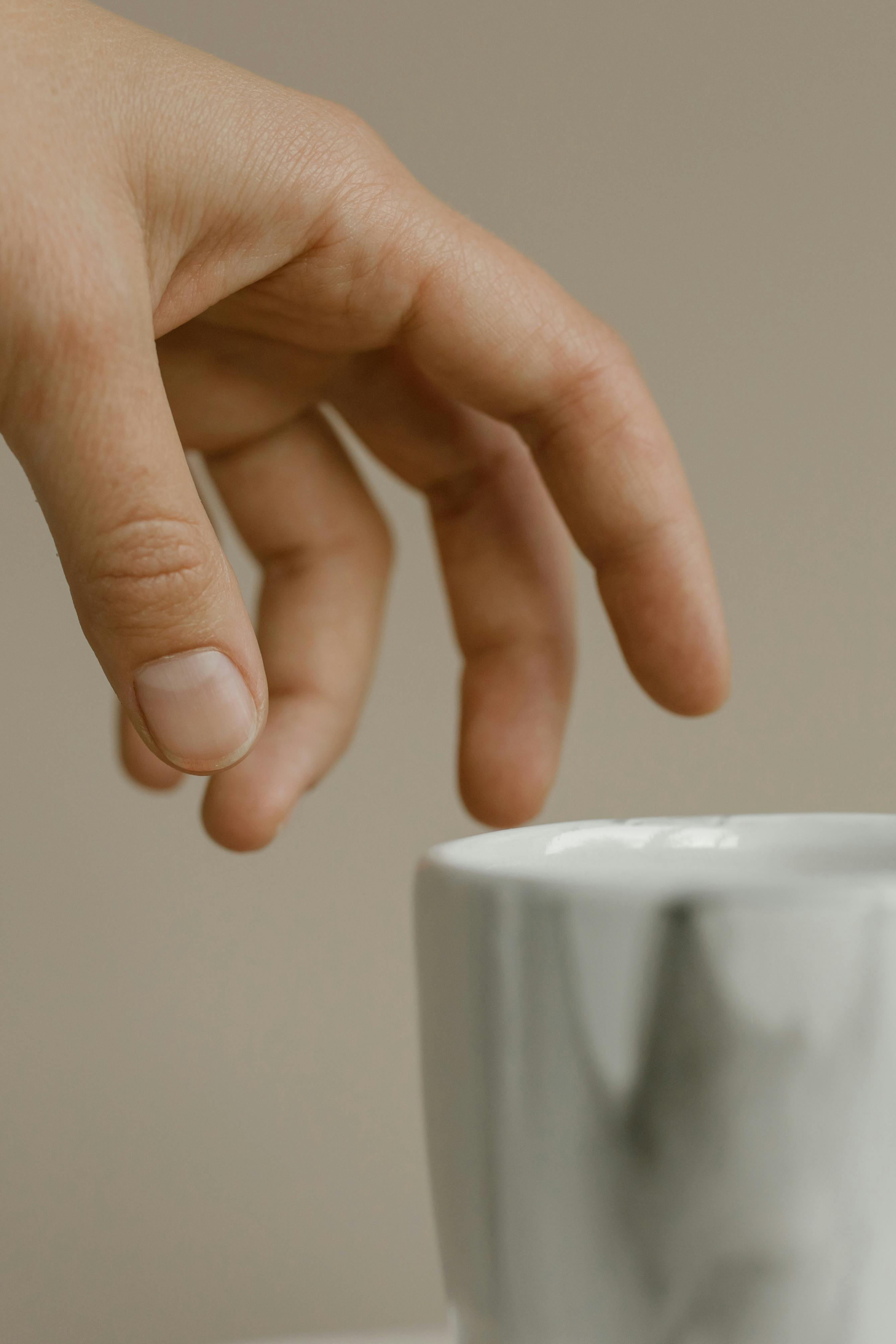 Photo of a Hand Reaching for a Cup · Free Stock Photo