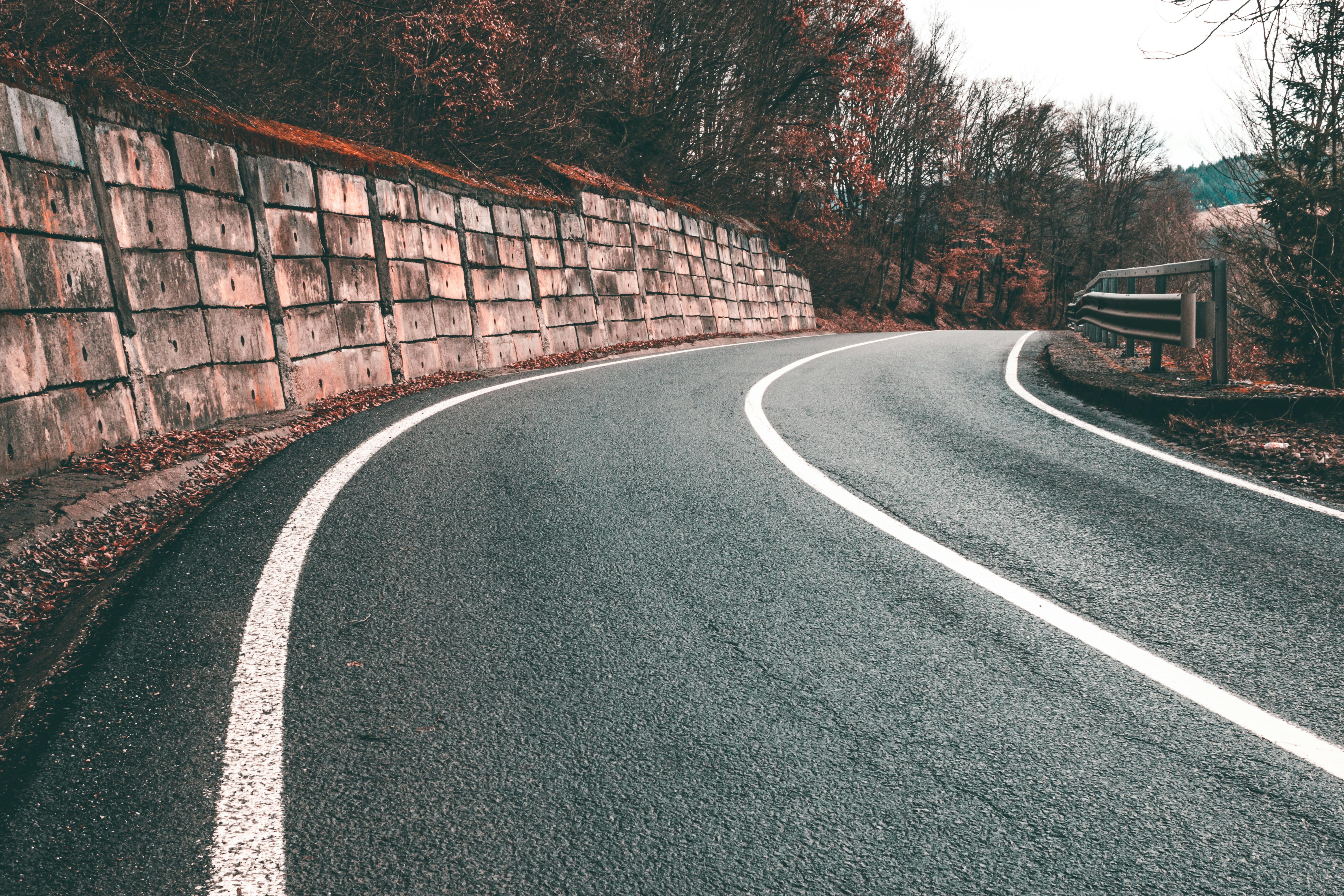 Gray Asphalt Road Near the Block Wall · Free Stock Photo