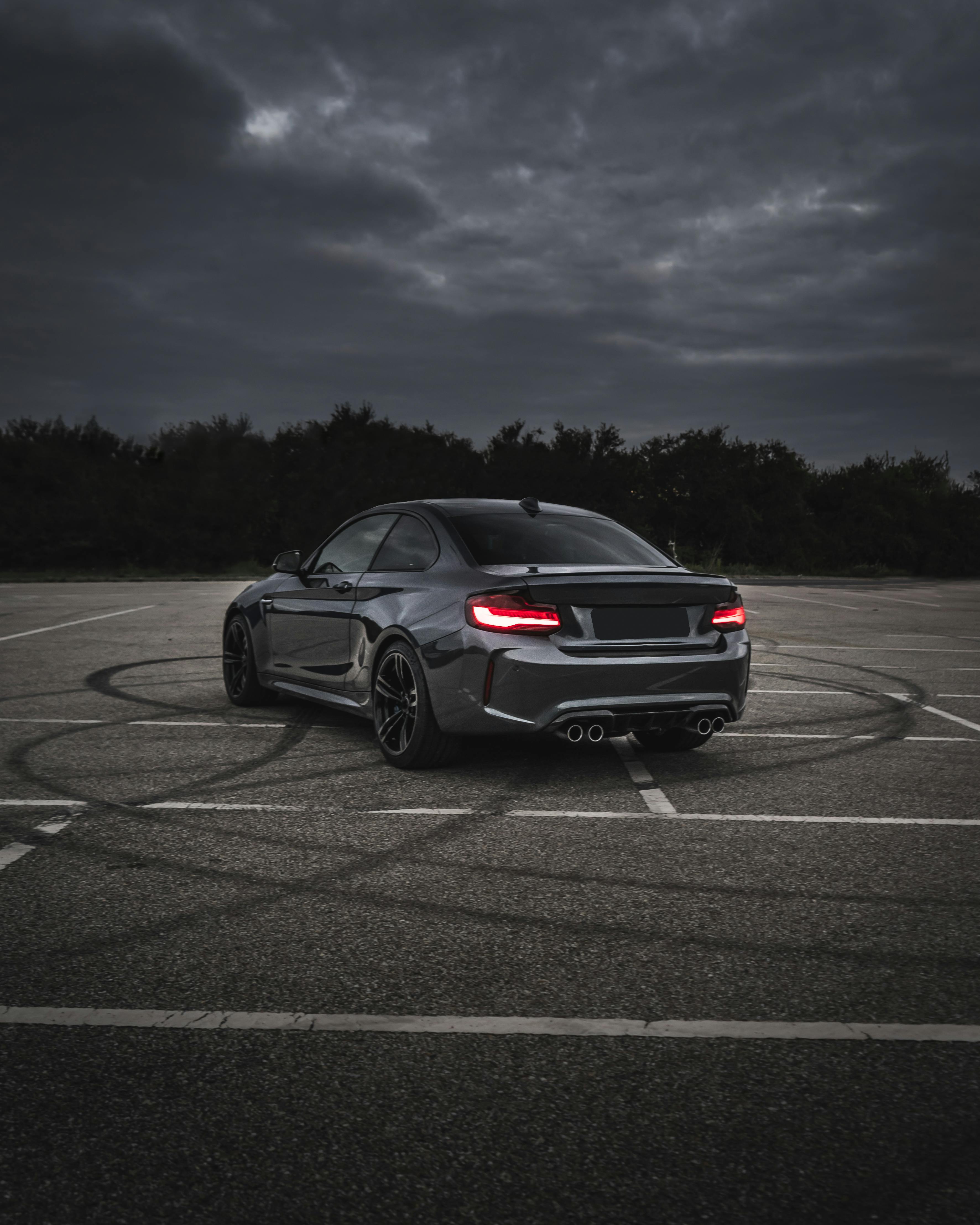 Back View Shot of Black Expensive Car Parked on an Asphalt Road Under ...