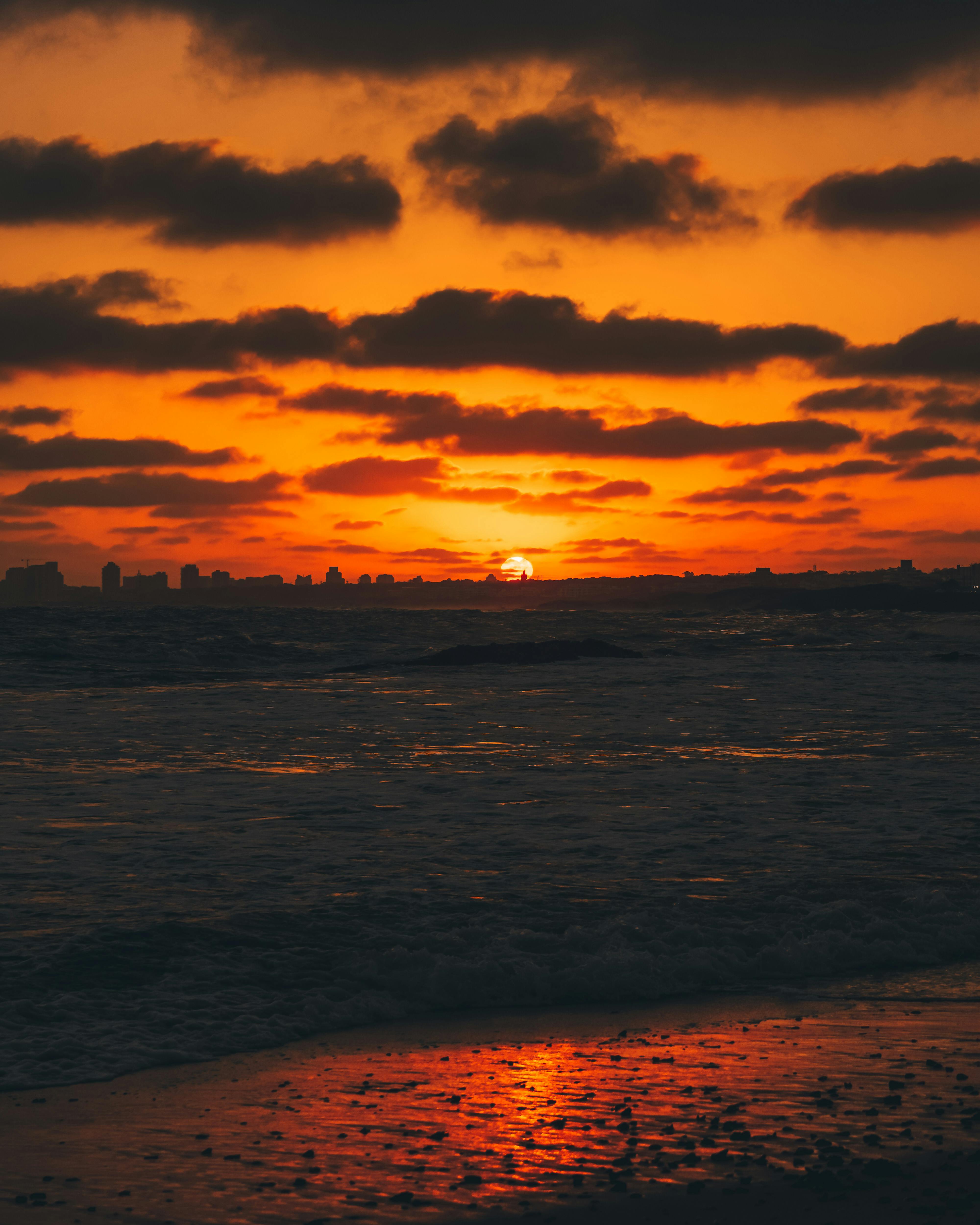 Sunset Cloudy Sky Over the Ocean Shore · Free Stock Photo