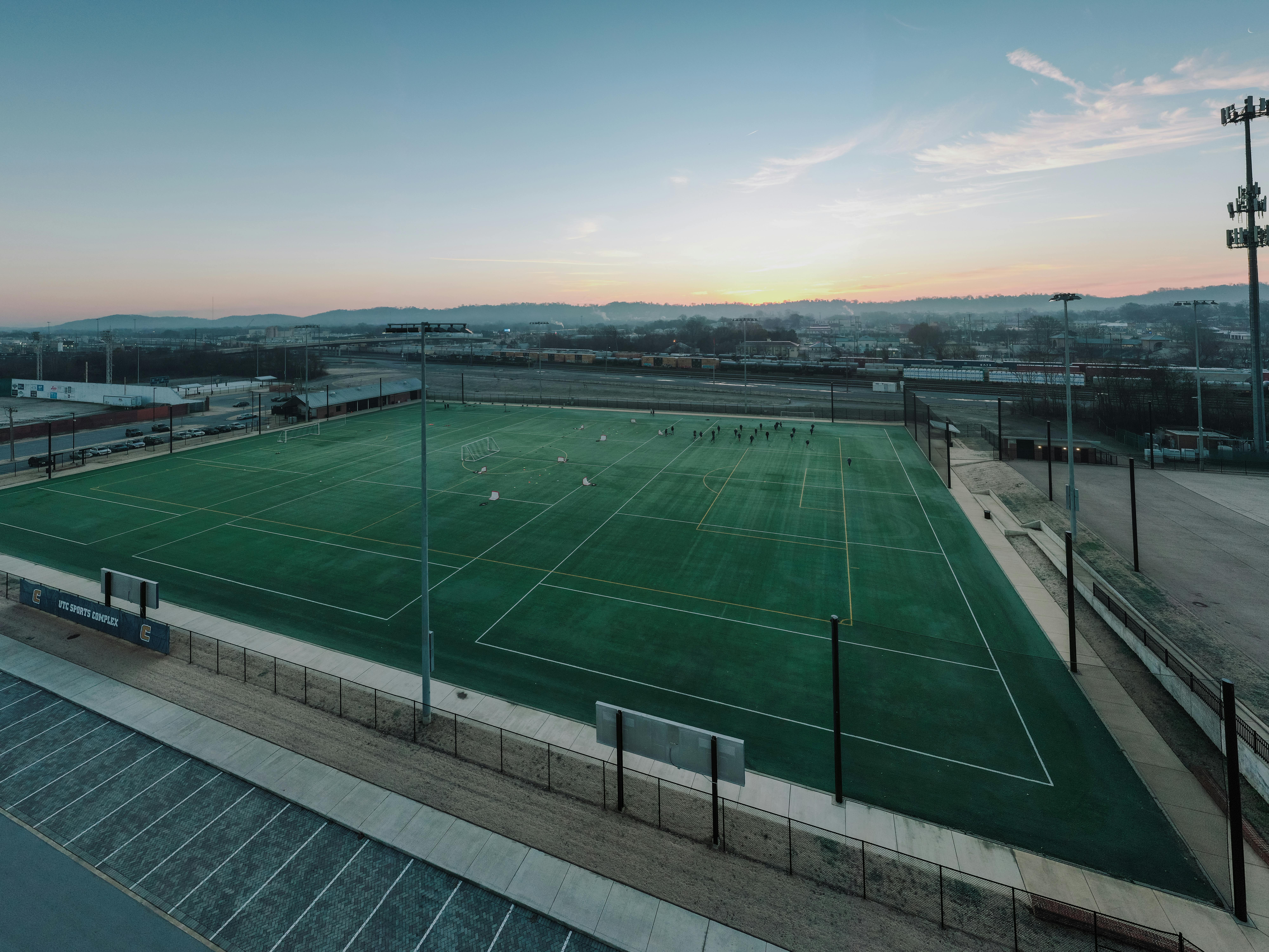 Grassy sports ground in town at sunset · Free Stock Photo