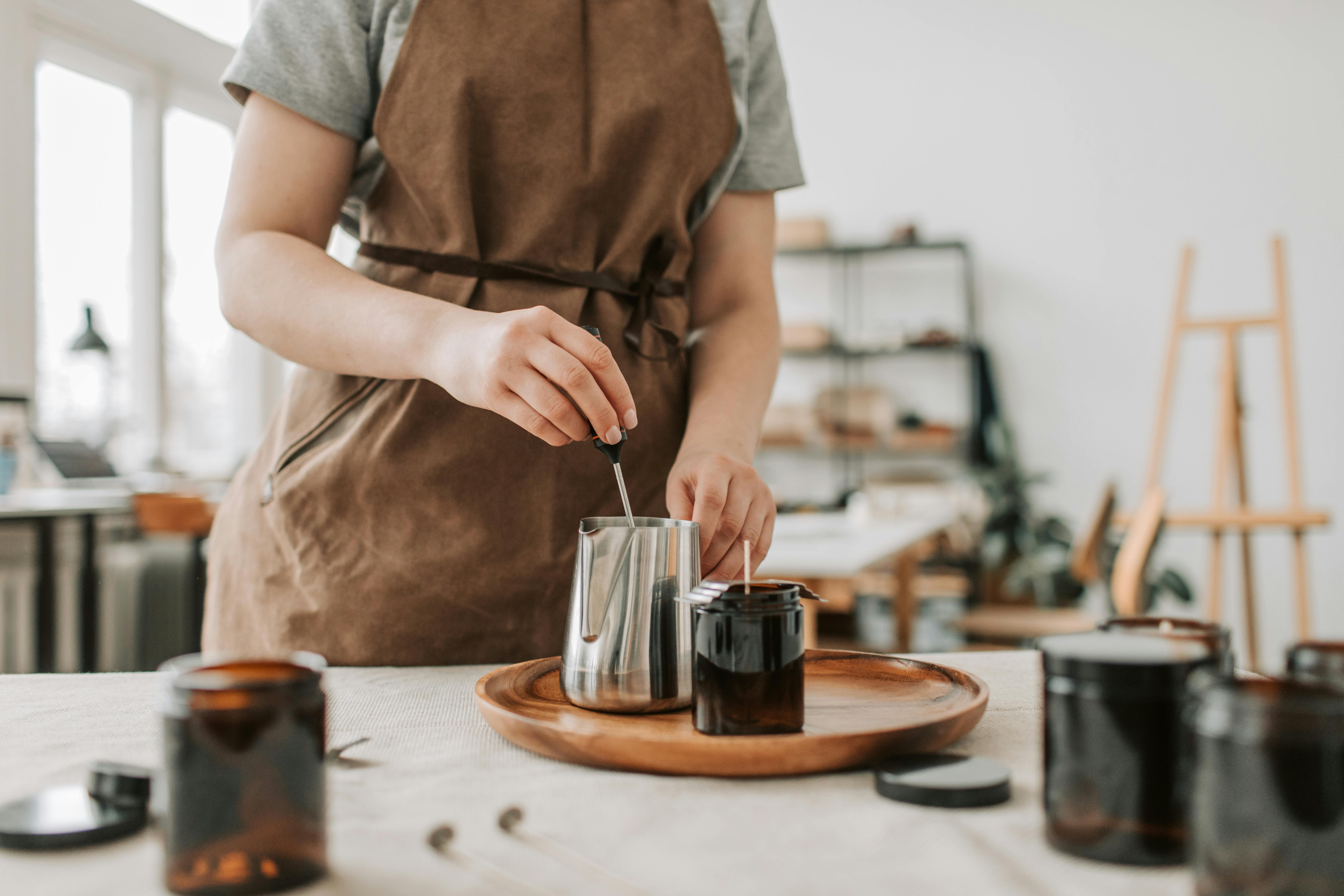 Person Wearing an Apron Holding a Stainless Pitcher · Free Stock Photo