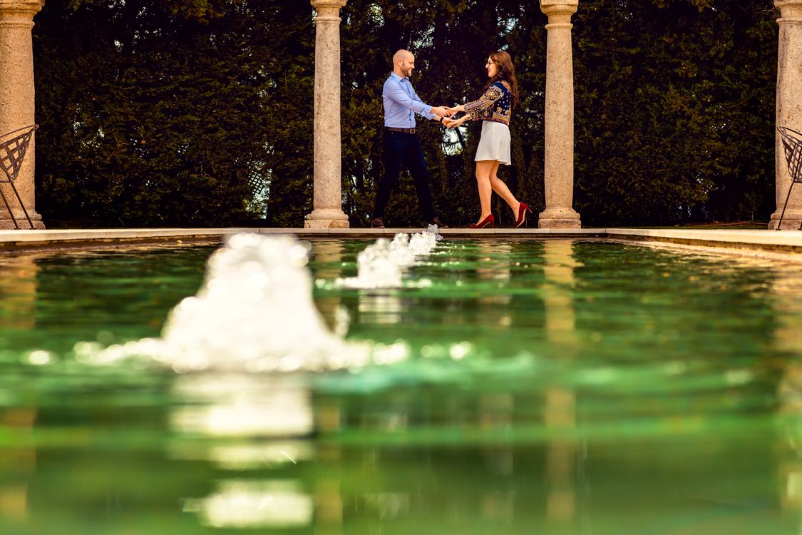 A Couple Standing Near The Water Fountain While Holding Hands Free a-couple-standing-near-the-water-fountain-while-holding-hands-free