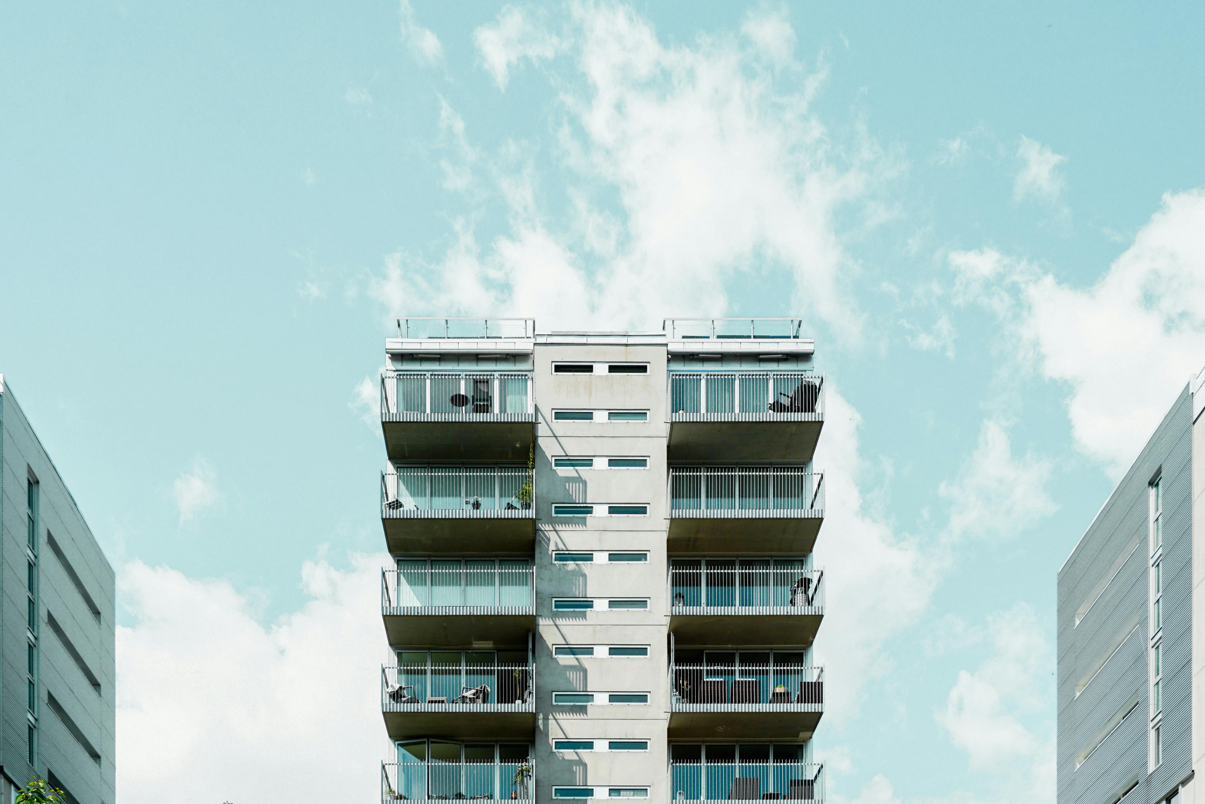 Two Men Leaning on the Balcony of the Concrete Building · Free Stock Photo