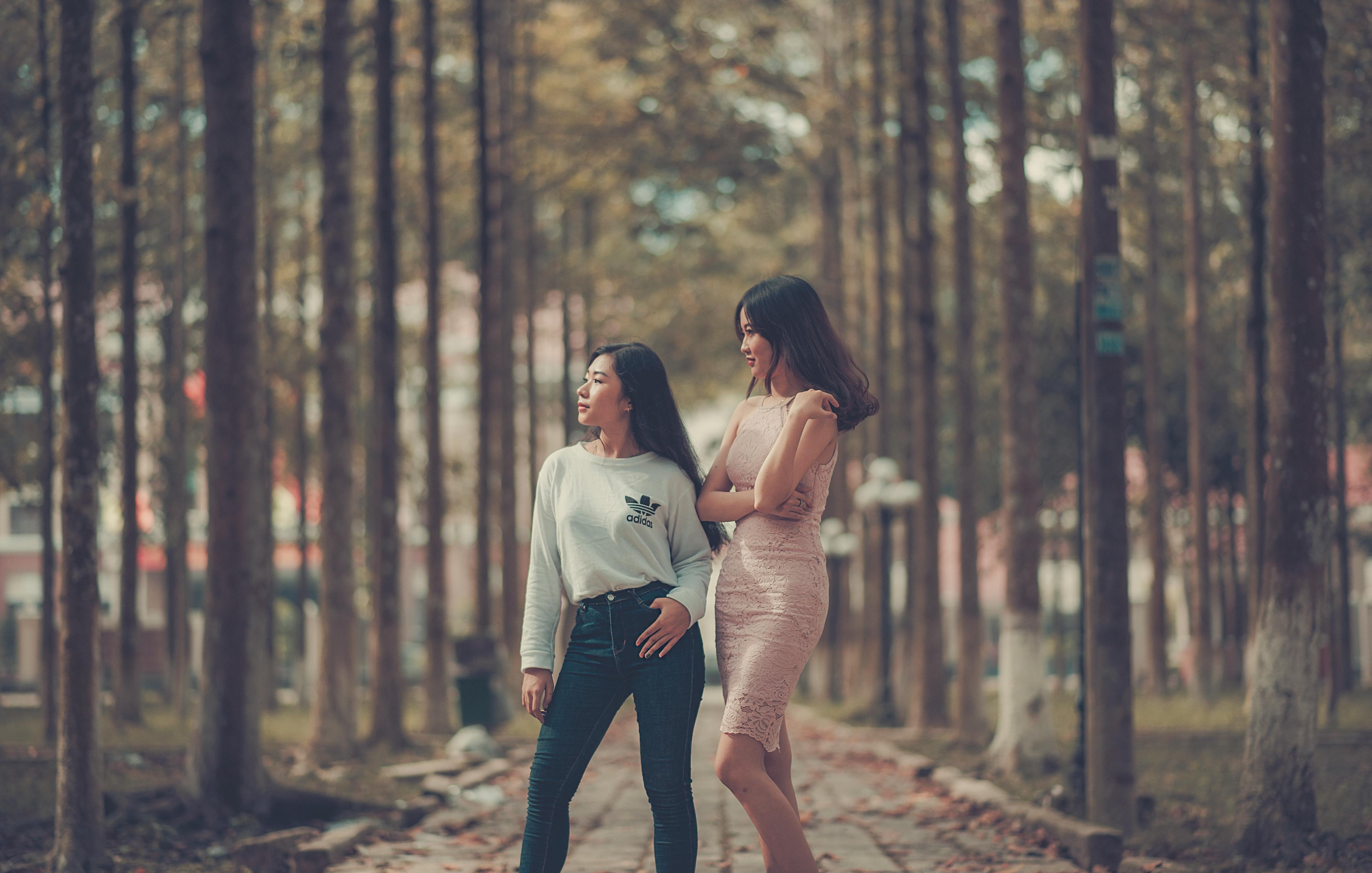 Two Woman Standing on Sidewalk Near Trees · Free Stock Photo
