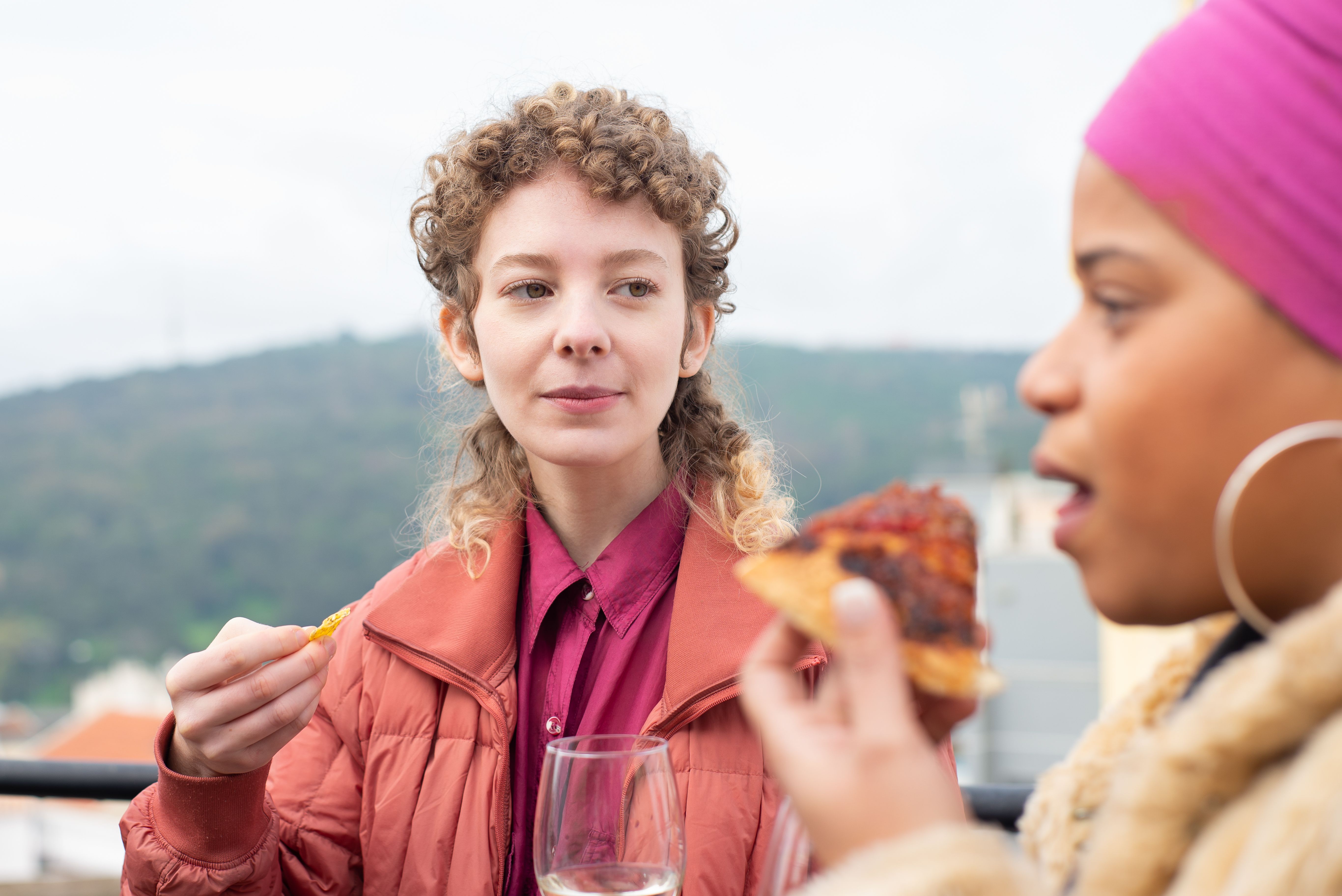 Woman in a Jacket Eating Snacks · Free Stock Photo