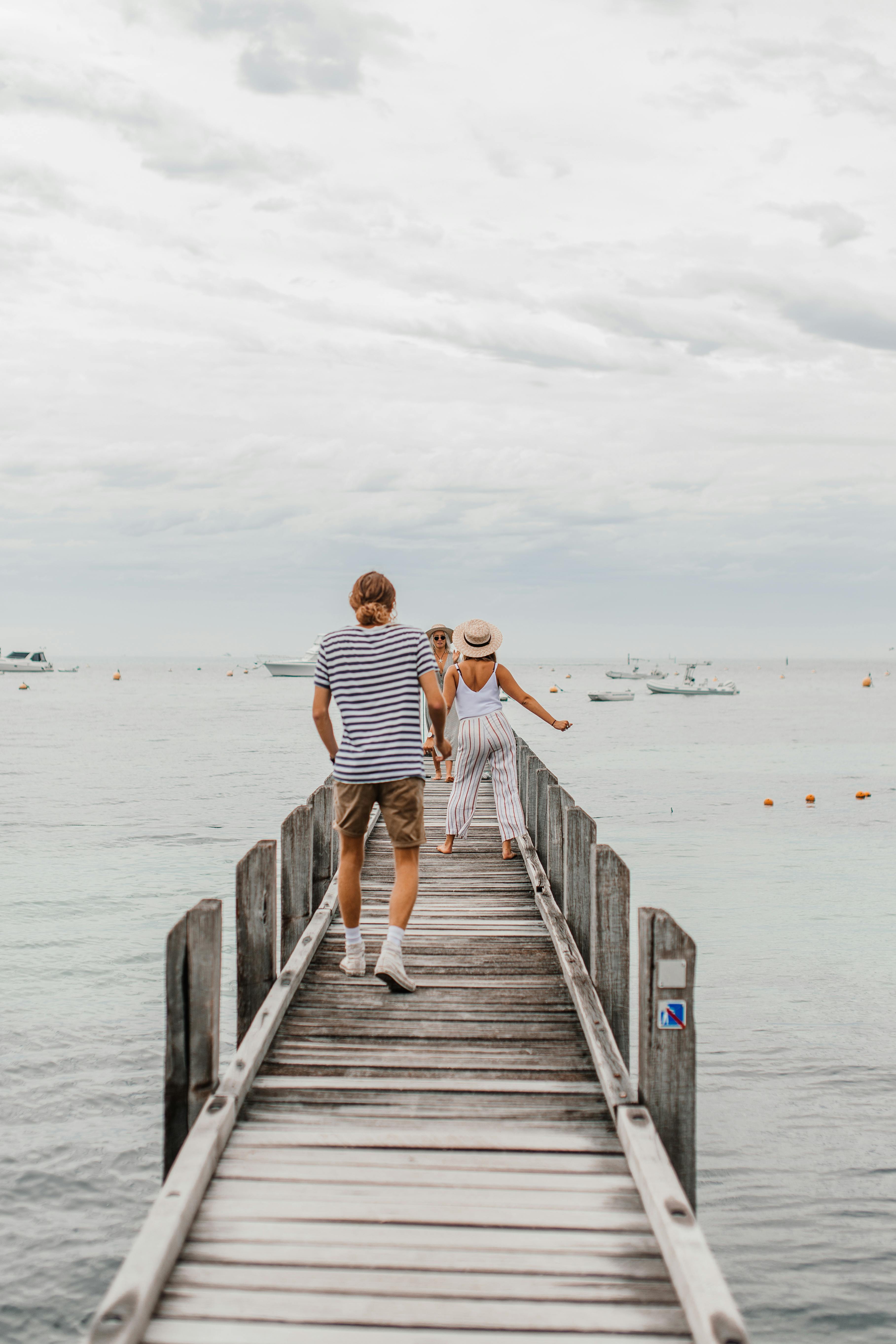 Back View Shot of People Walking on the Wooden Dock · Free Stock Photo