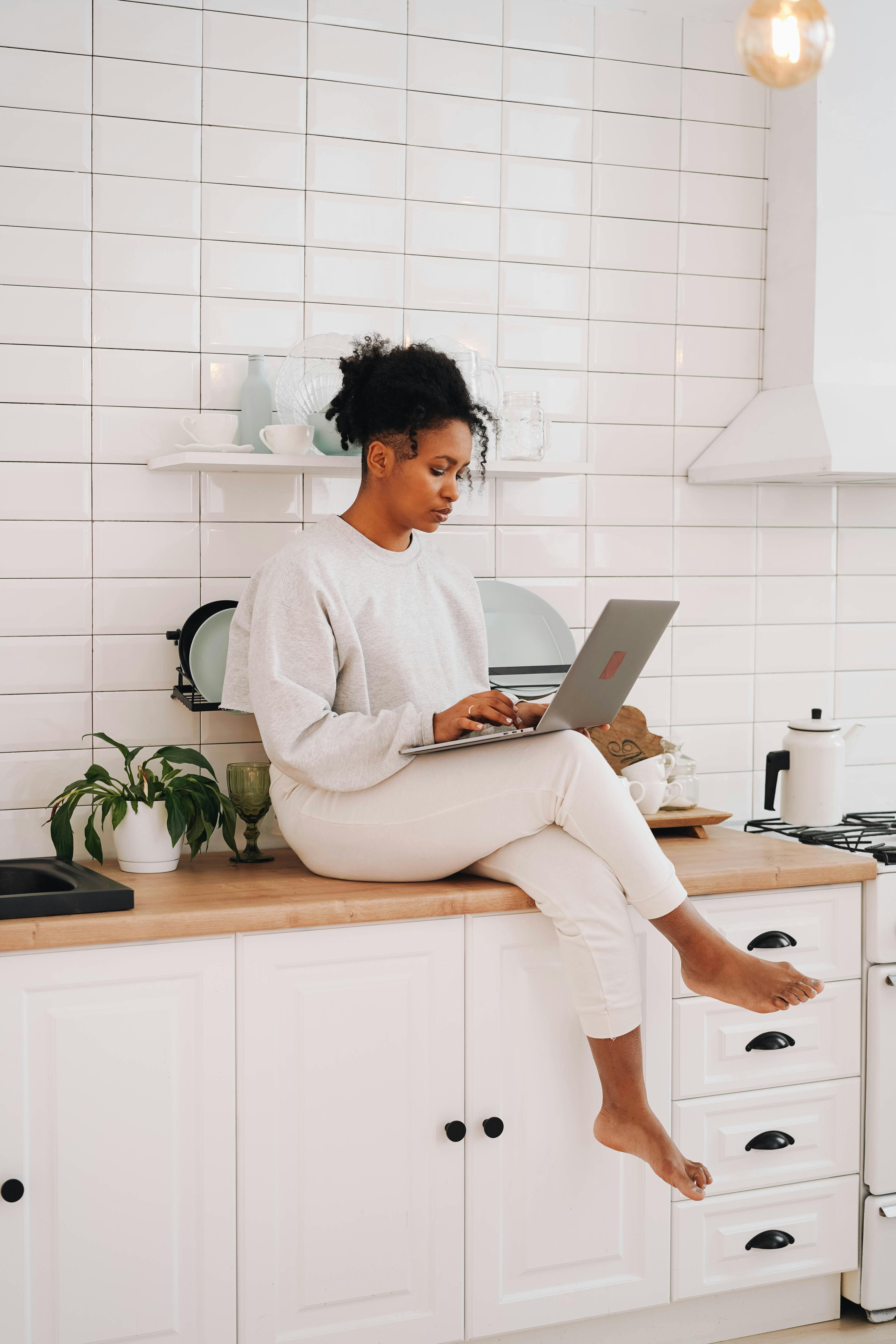 A Woman Sitting on the Kitchen Counter · Free Stock Photo