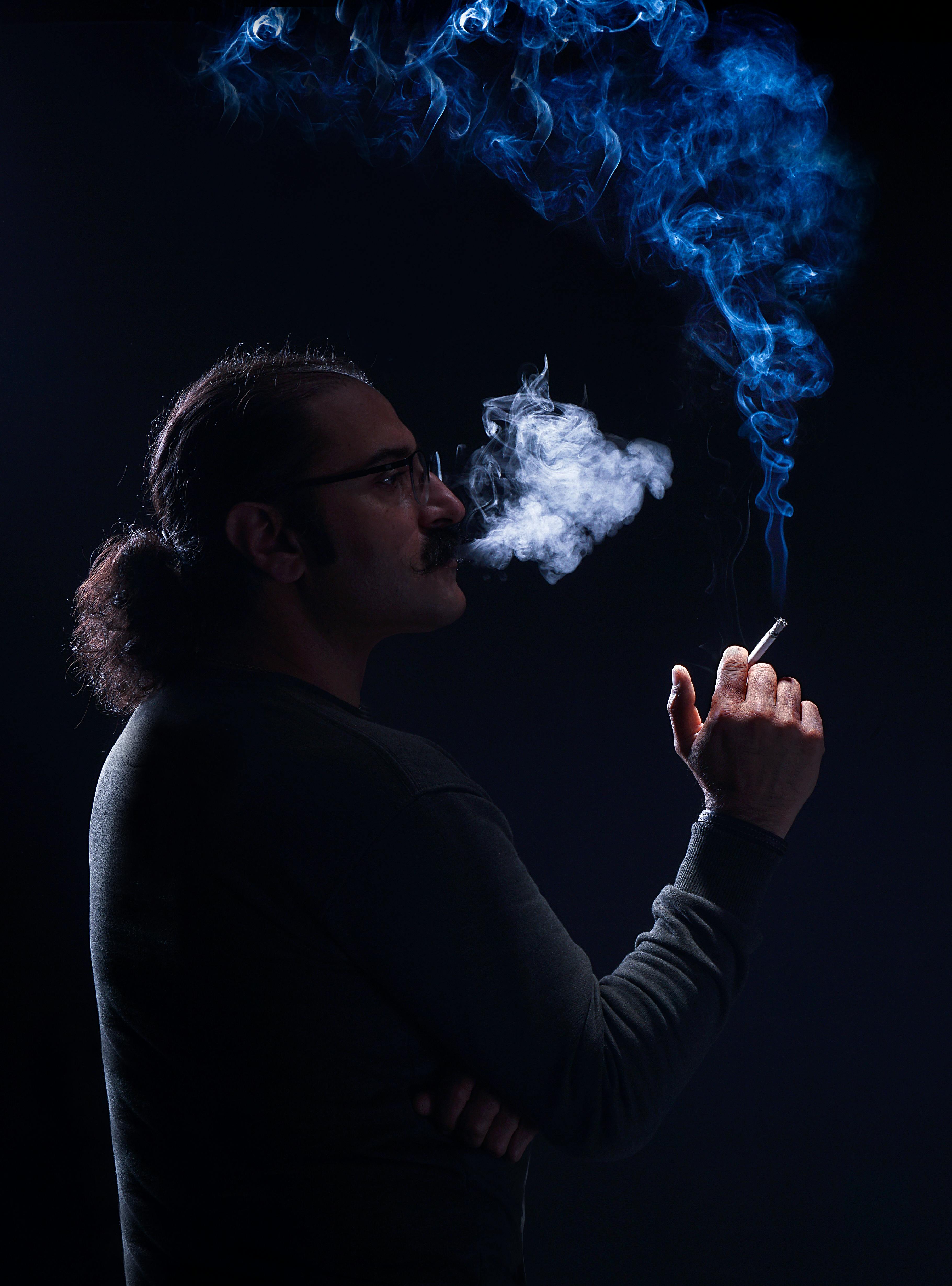 Man with Long Hair and Moustache Smoking a Cigarette · Free Stock Photo