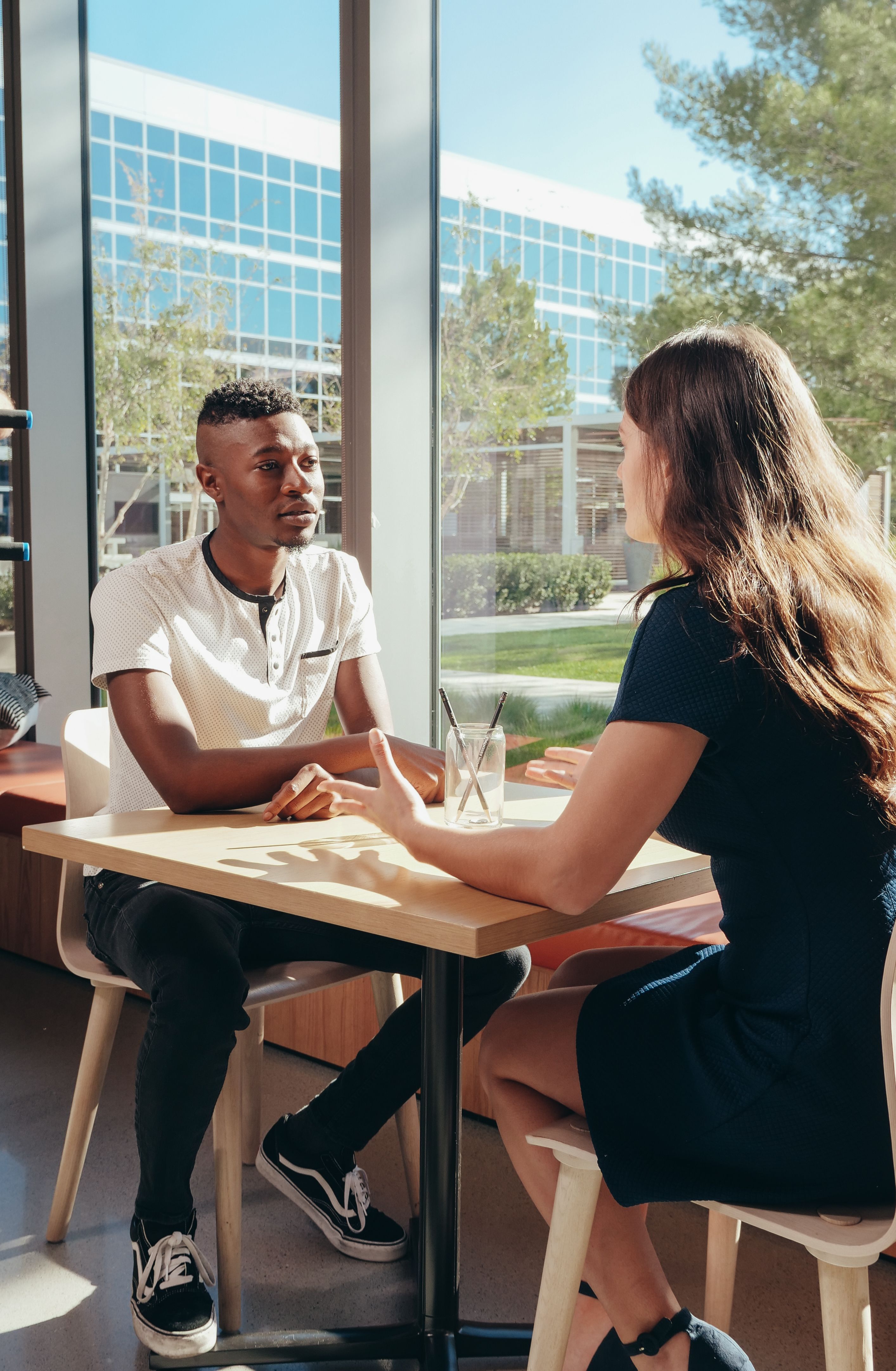 A Man and a Woman Talking while Sitting Down · Free Stock Photo