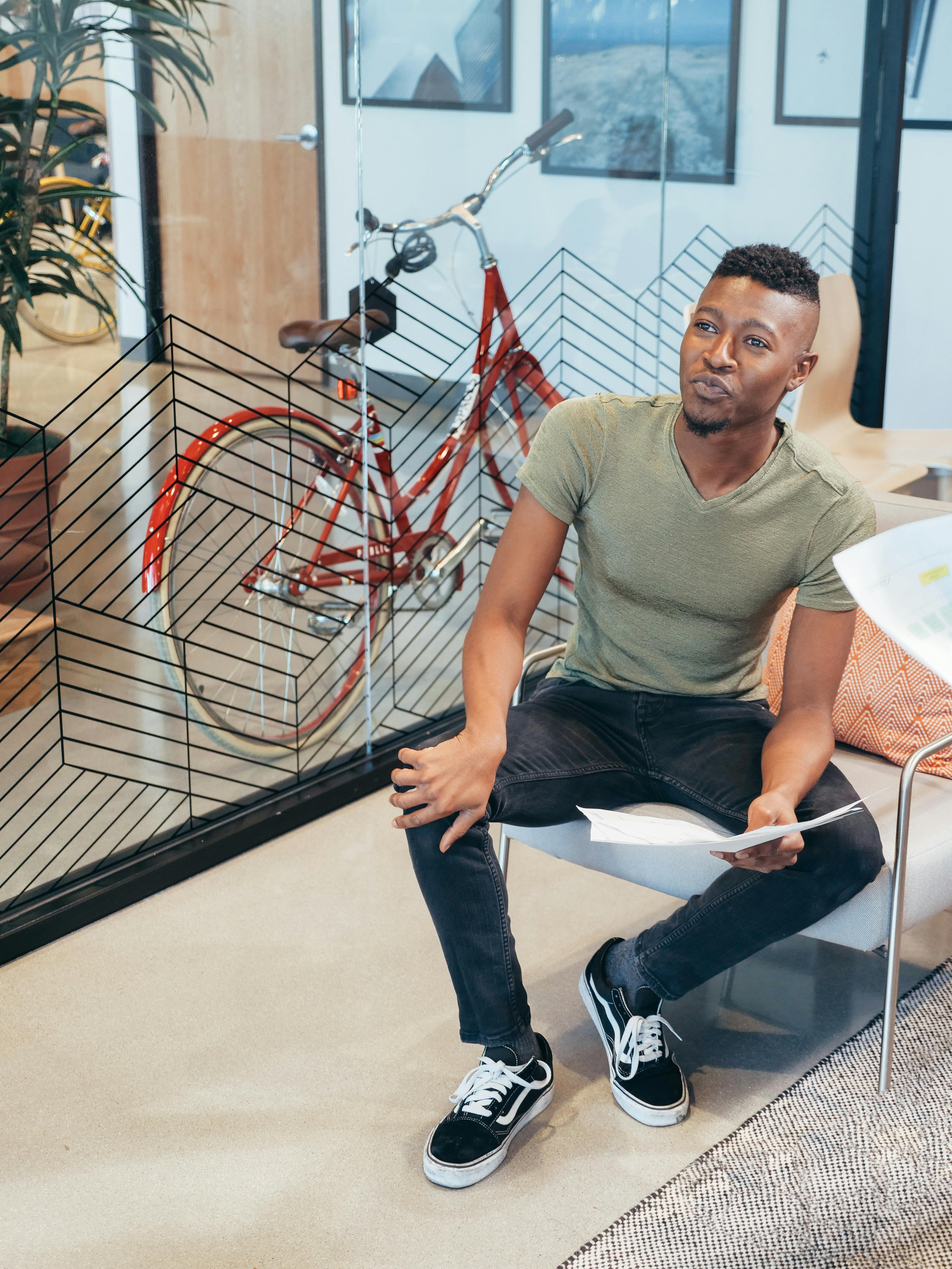 Man Wearing Red While Sitting Inside Concrete Bulding · Free Stock Photo