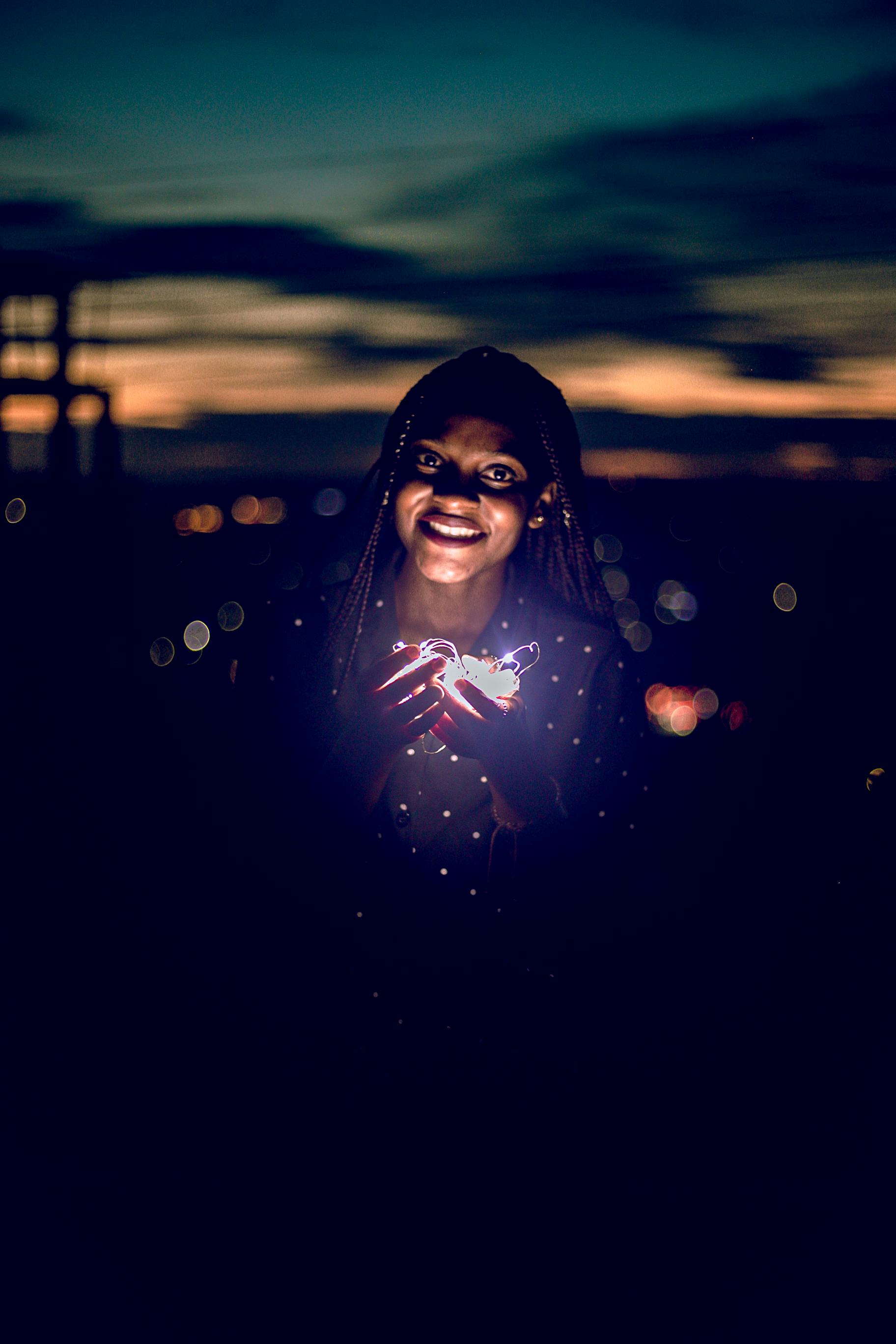 Woman Smiling while Holding Lights · Free Stock Photo
