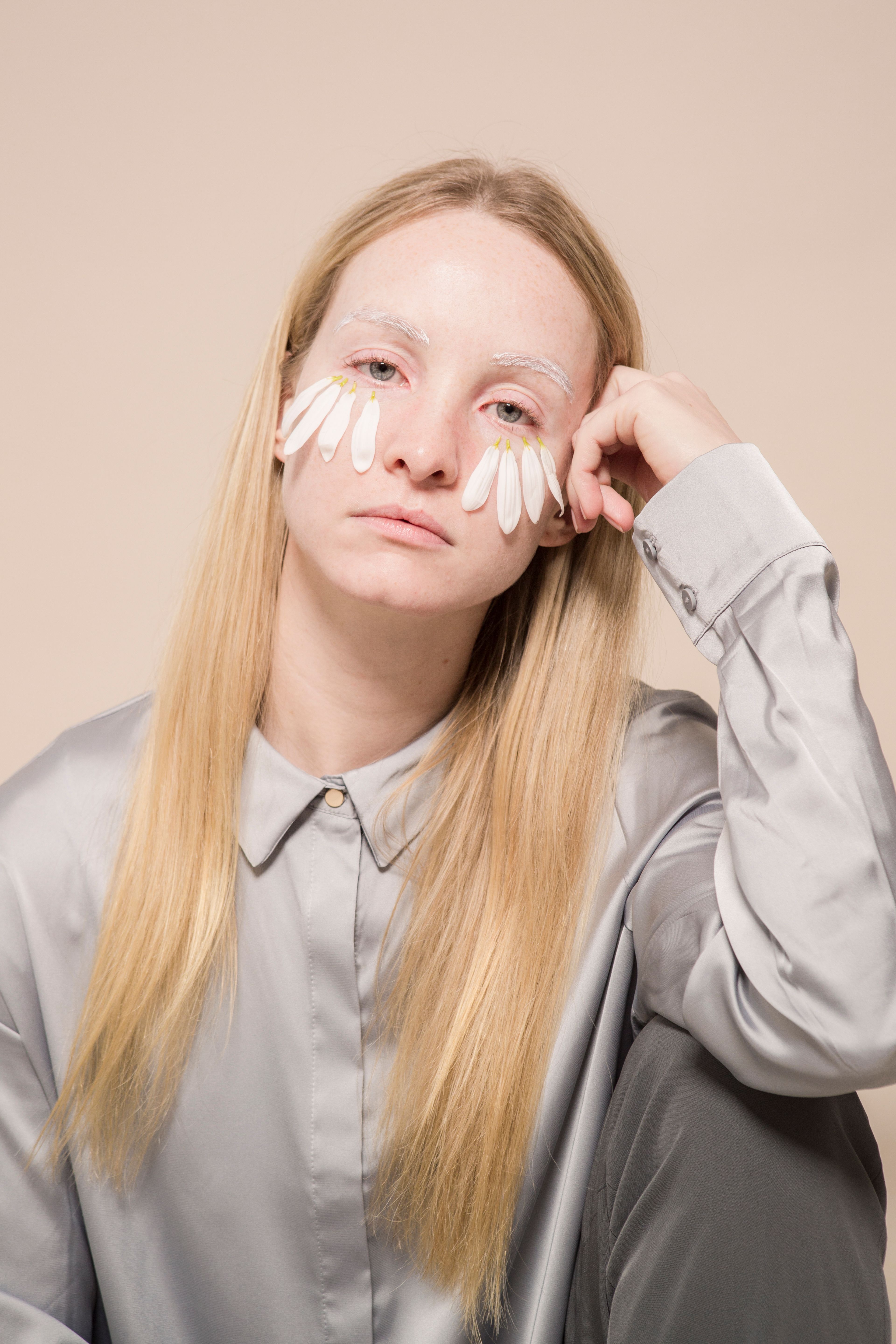 Emotionless woman with petals on face · Free Stock Photo