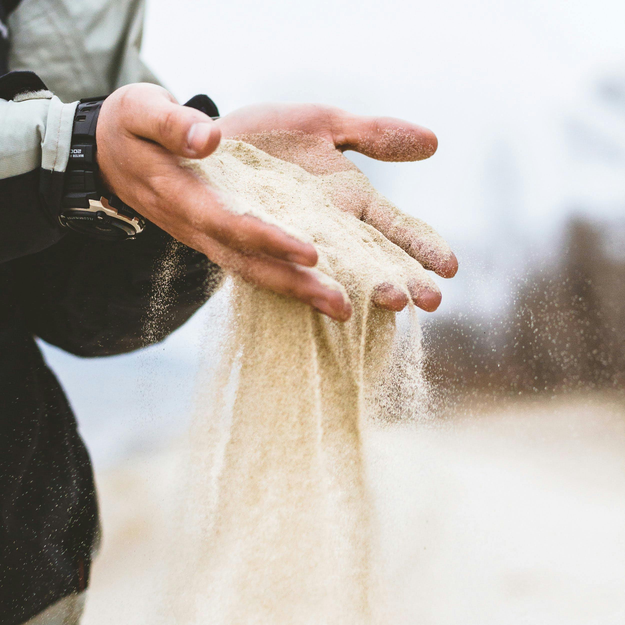 Man pouring small pieces of sand on coat · Free Stock Photo
